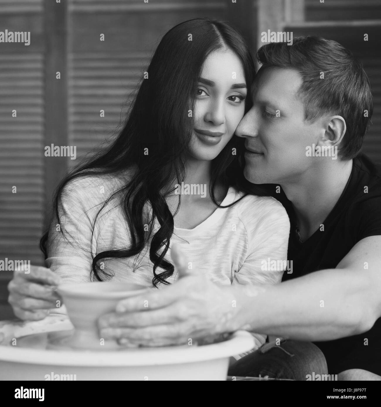 Romantic caucasian couple sculpring clay at pottr wheel. Making pottery ...