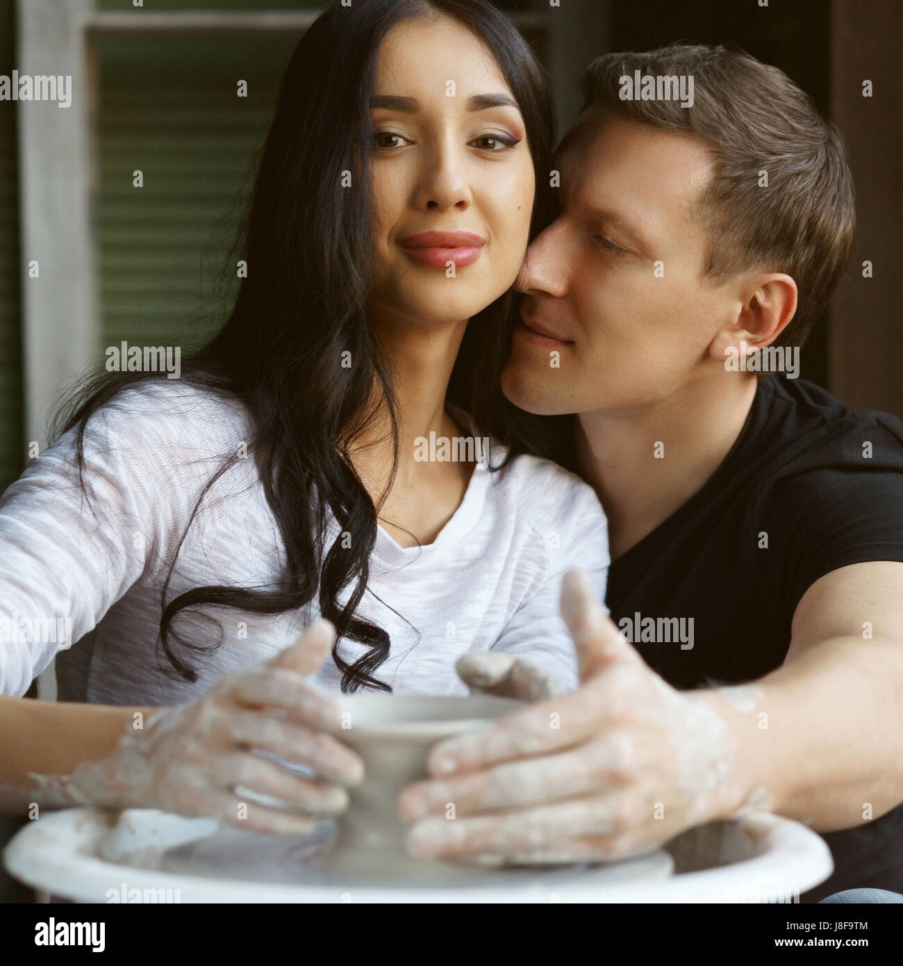 Pottery. Young romantic couple working on potter wheel and scilpting ...