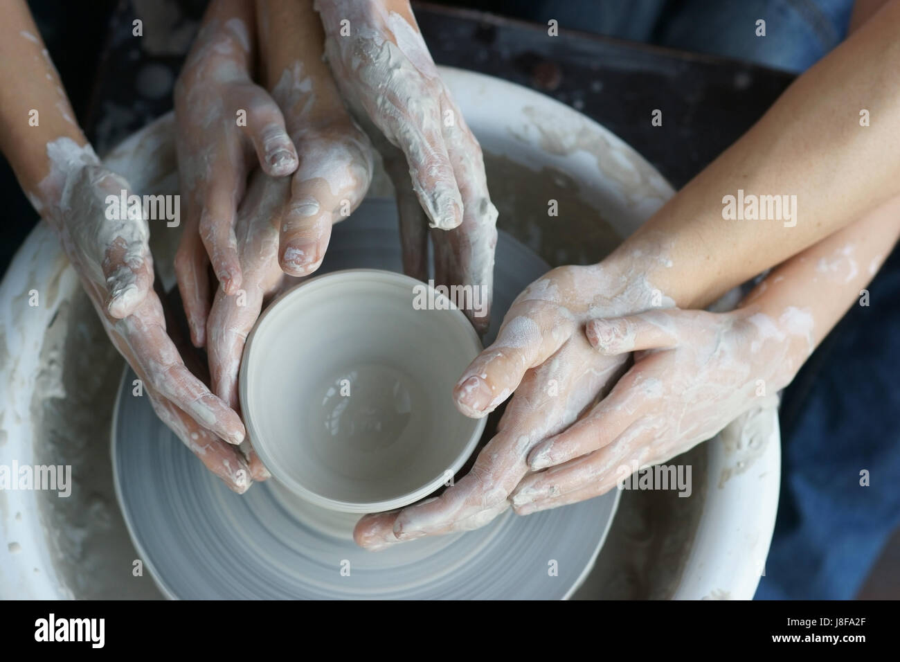 Family working on pottery wheel. Top view of mother, father and son ...
