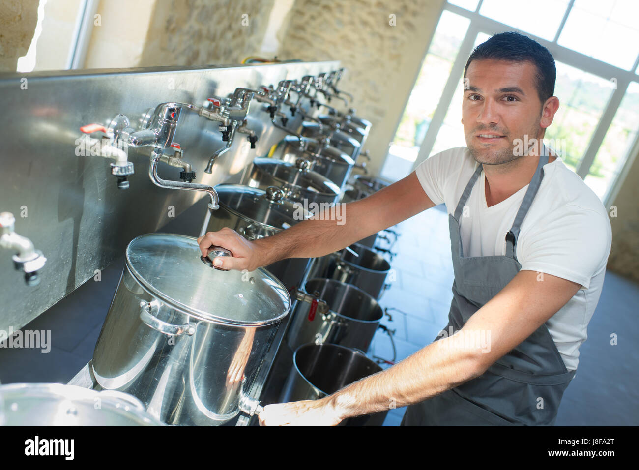 man filling large pans with water Stock Photo - Alamy