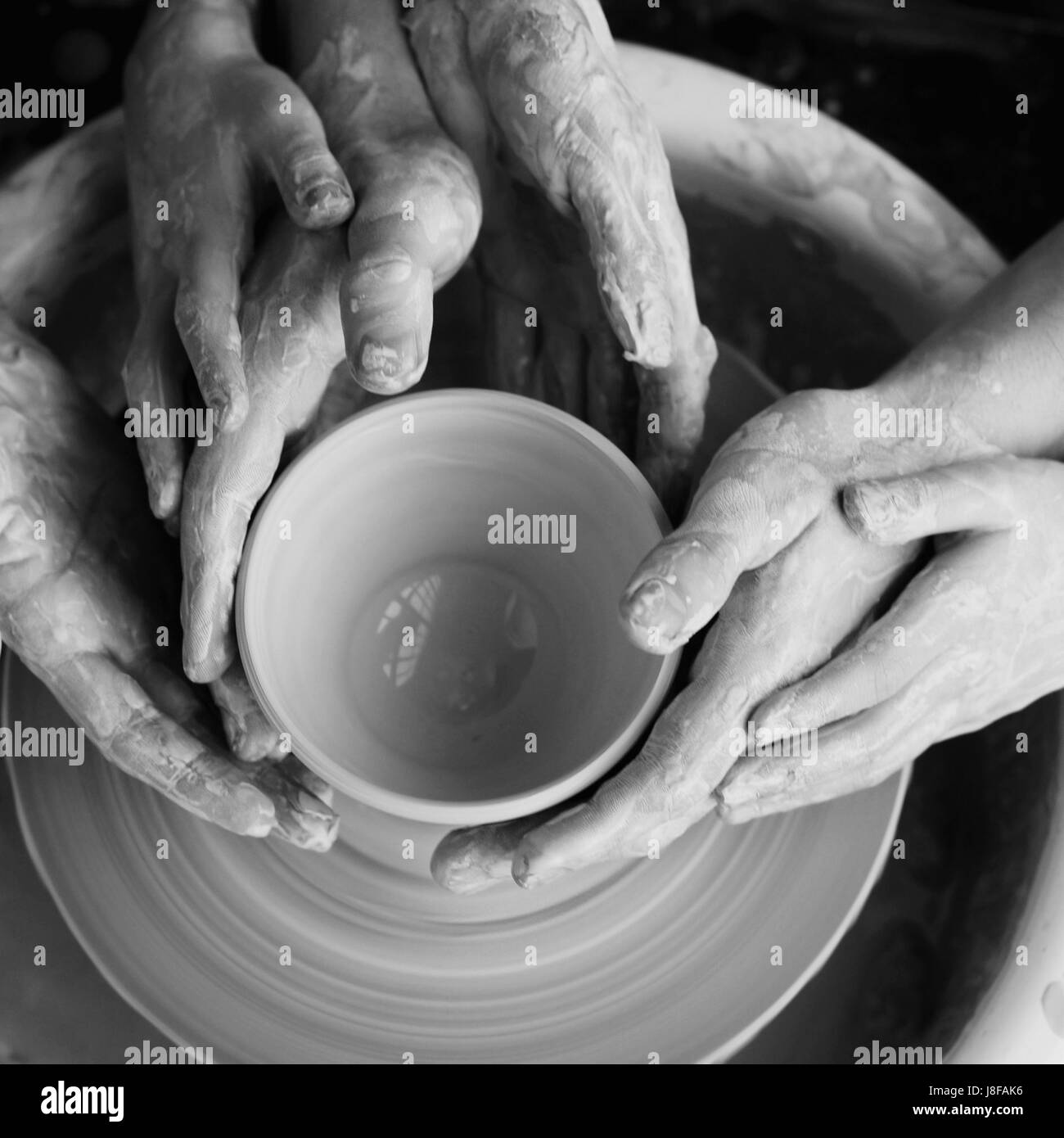 Family working on pottery wheel. Top view of mother, father and son ...