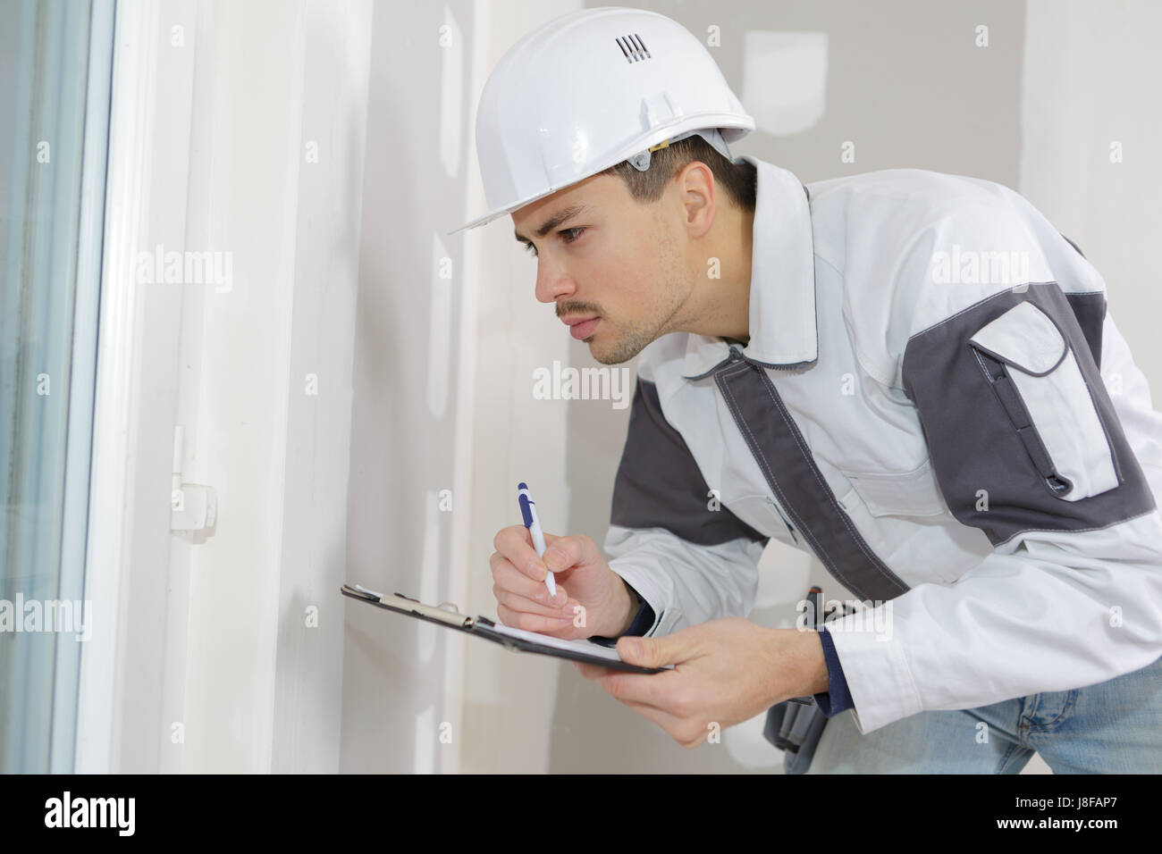 carpenter writing on clipboard Stock Photo - Alamy