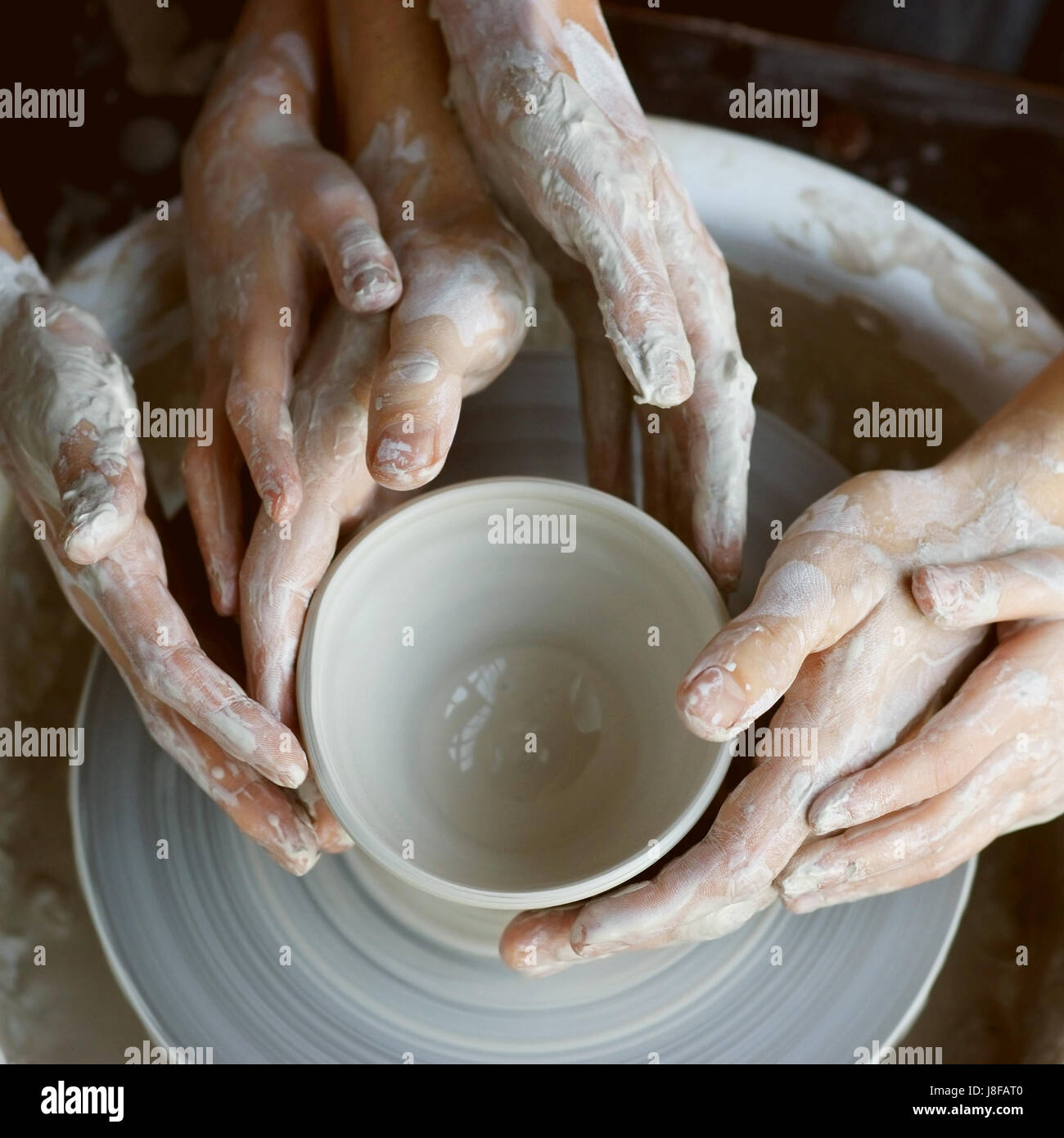 Family working on pottery wheel. Top view of mother, father and son ...