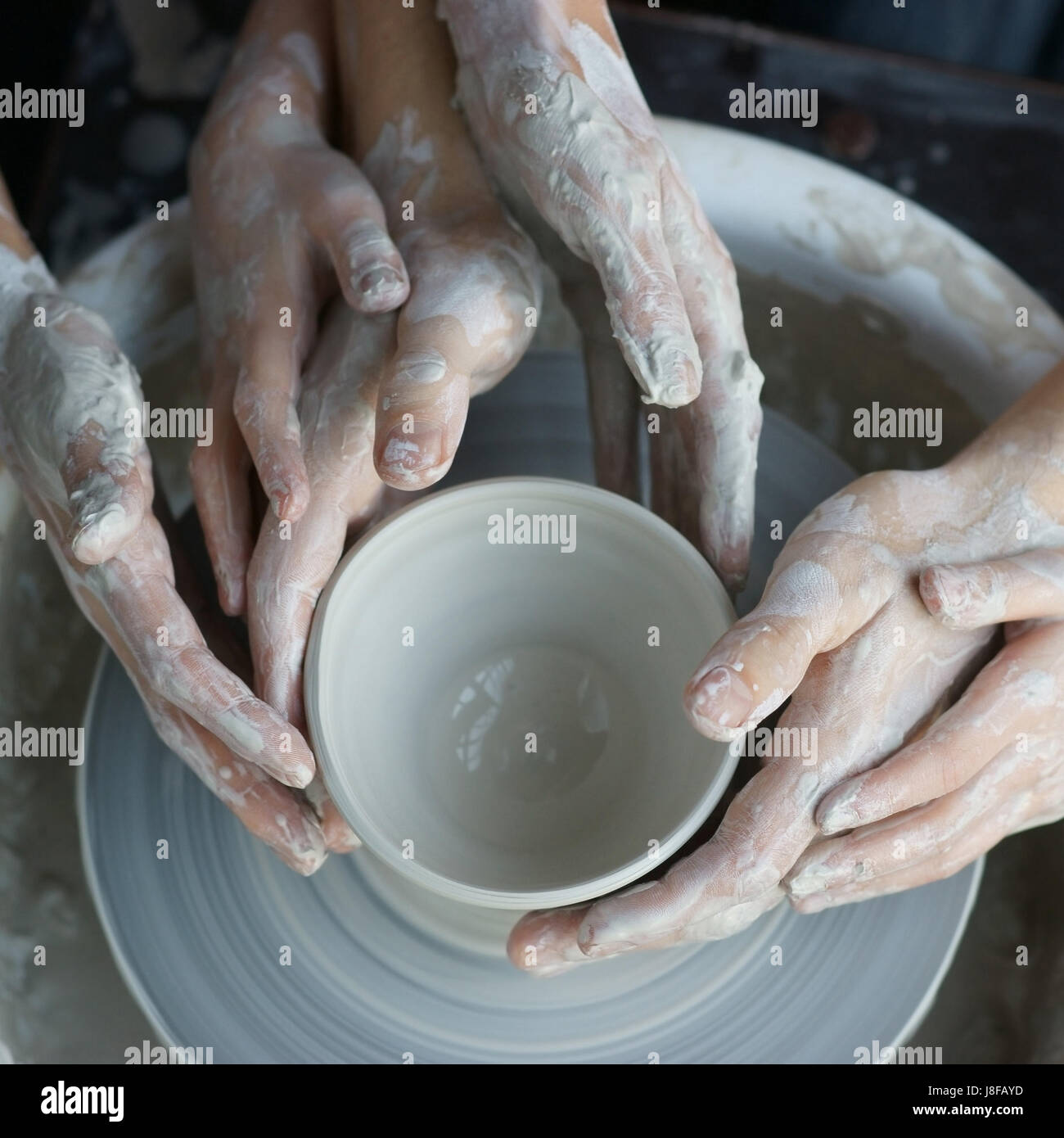 Family working on pottery wheel. Top view of mother, father and son ...