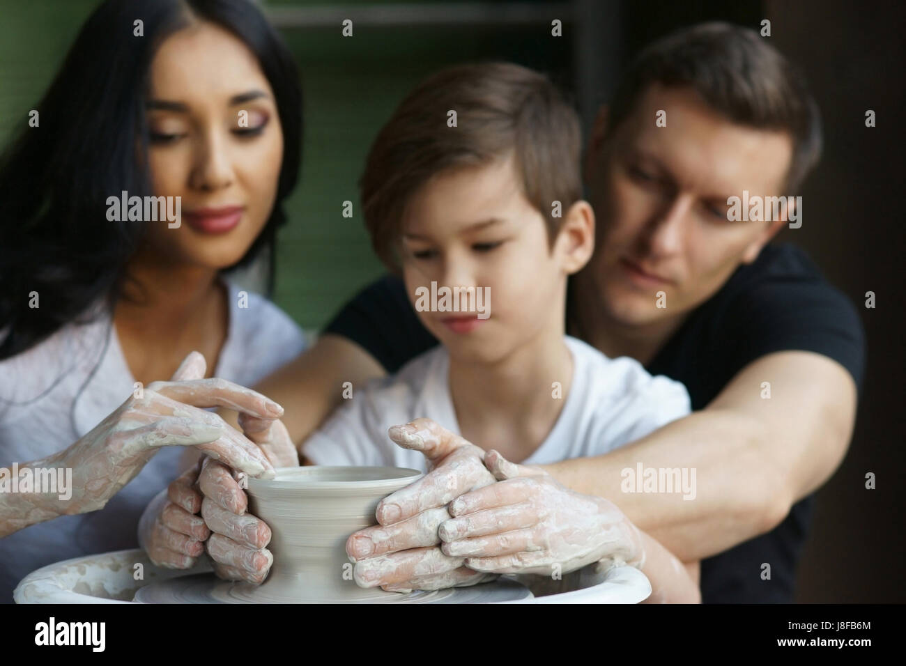 Family working on pottery wheel. Handsome man, beautiful pretty ...