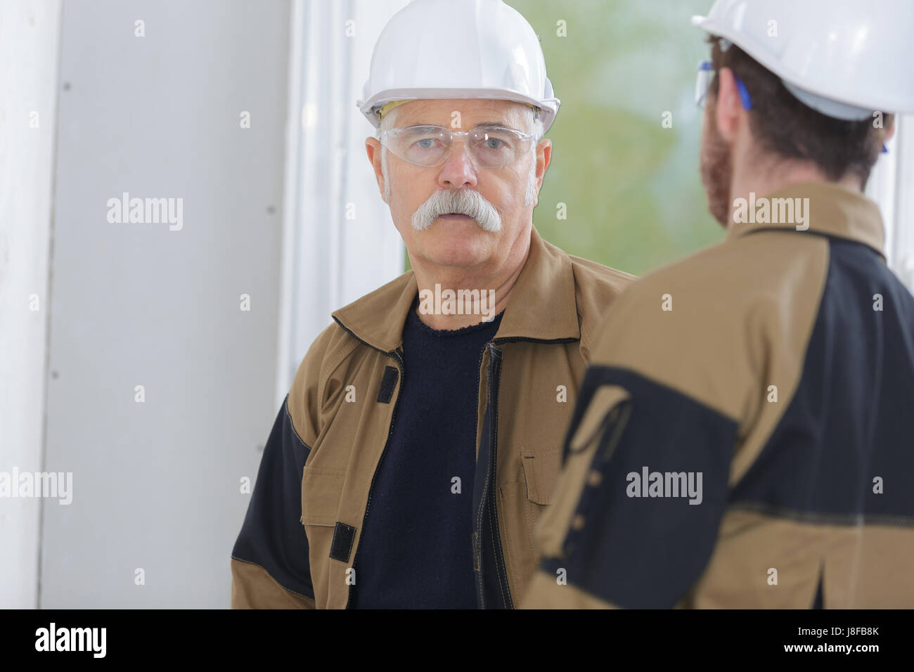 two builders having a conversation Stock Photo - Alamy