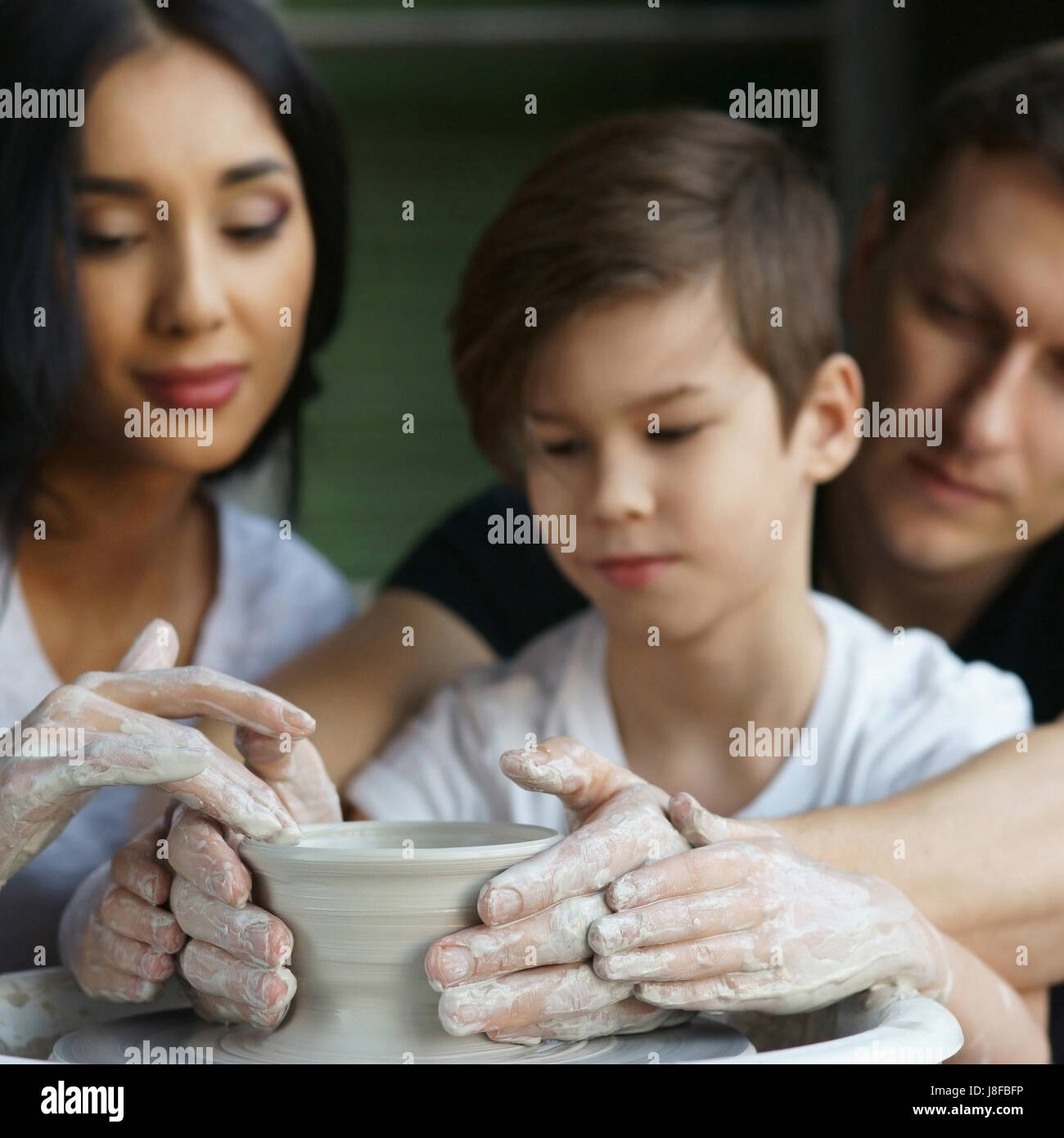Family working on pottery wheel. Handsome man, beautiful pretty ...