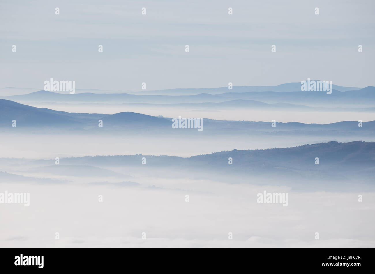 A sea of fog with some layered, distant mountains Stock Photo - Alamy