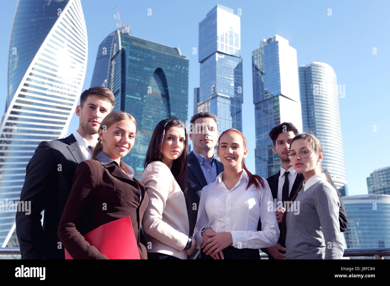 Portrait of business team outside office on skyscrapers background ...