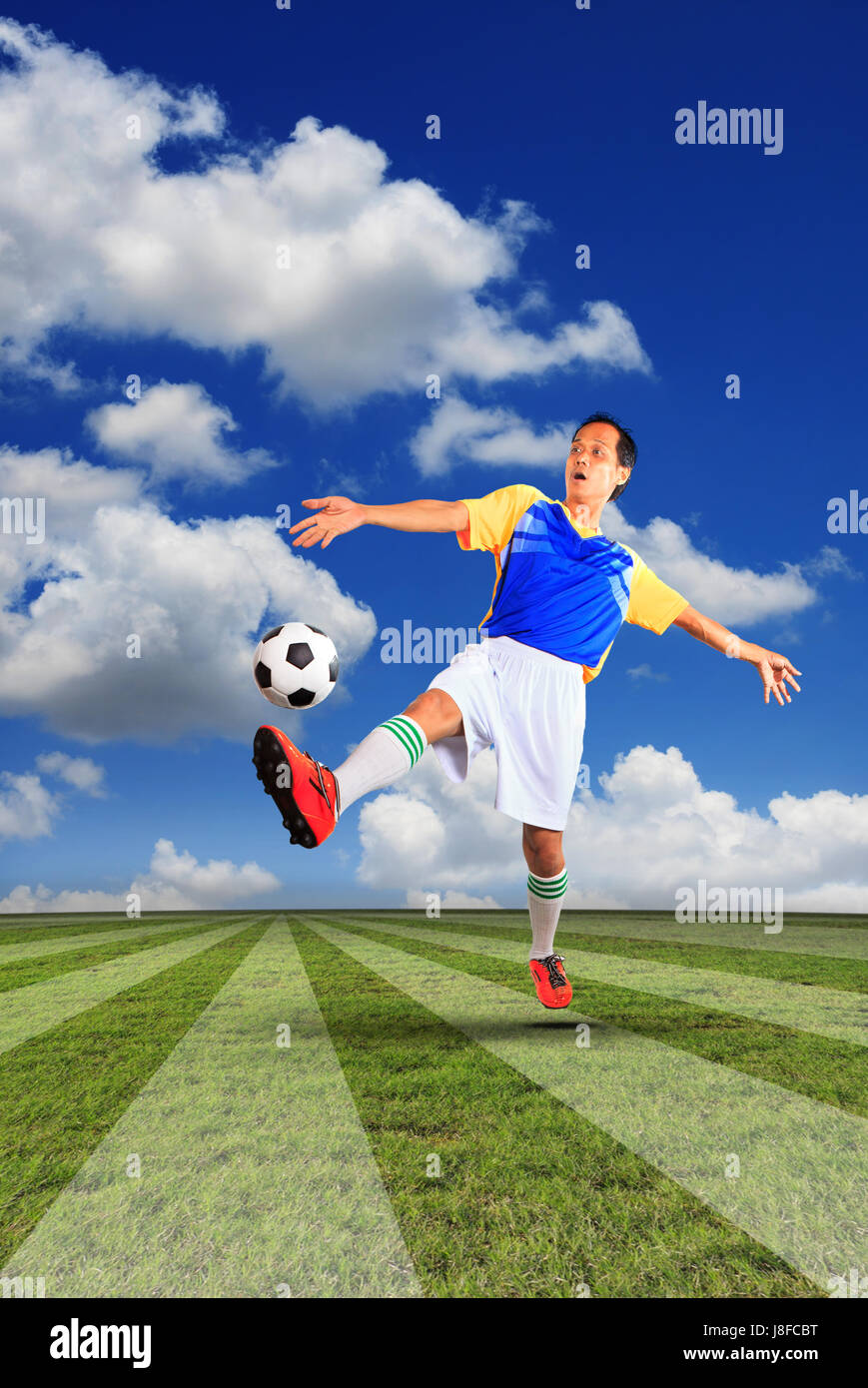 male football player and soccer ball floating on green grass of sport ...