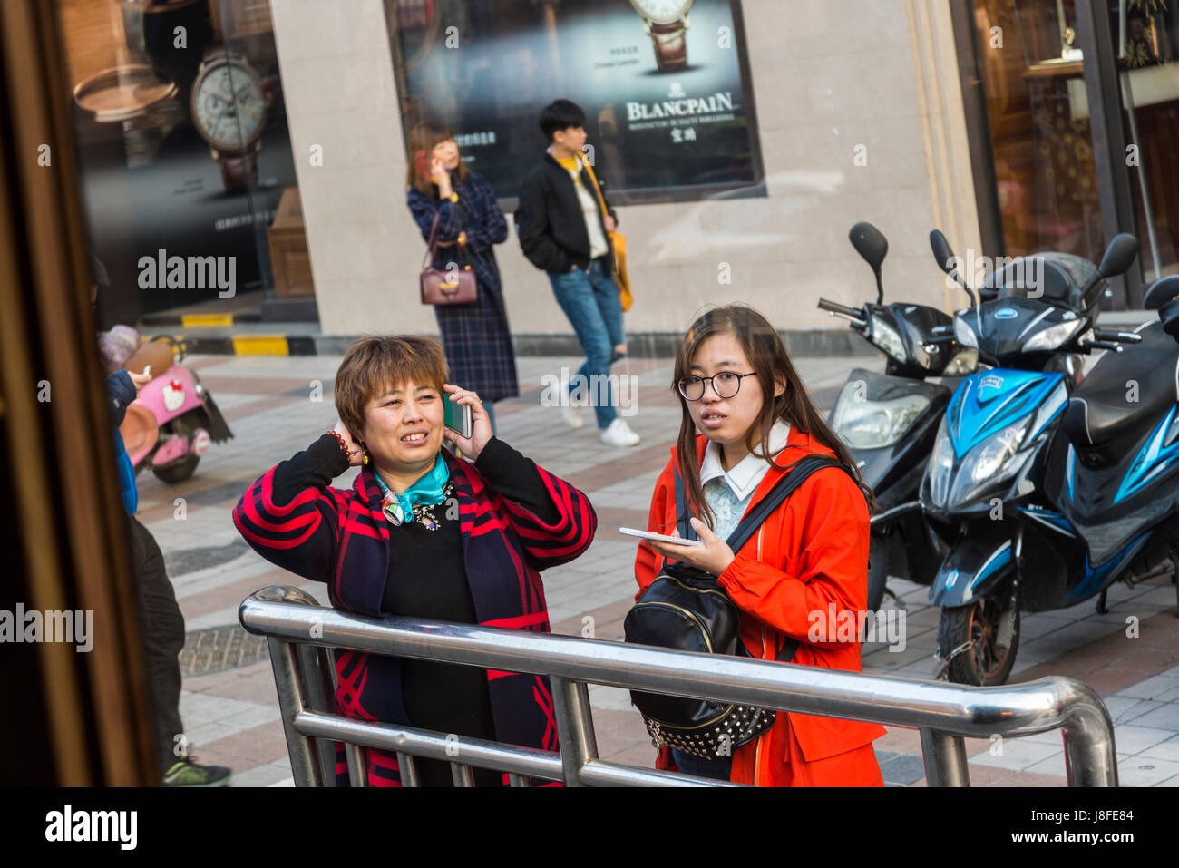 Street scene with women with mobile phones, Beijing, China Stock Photo ...