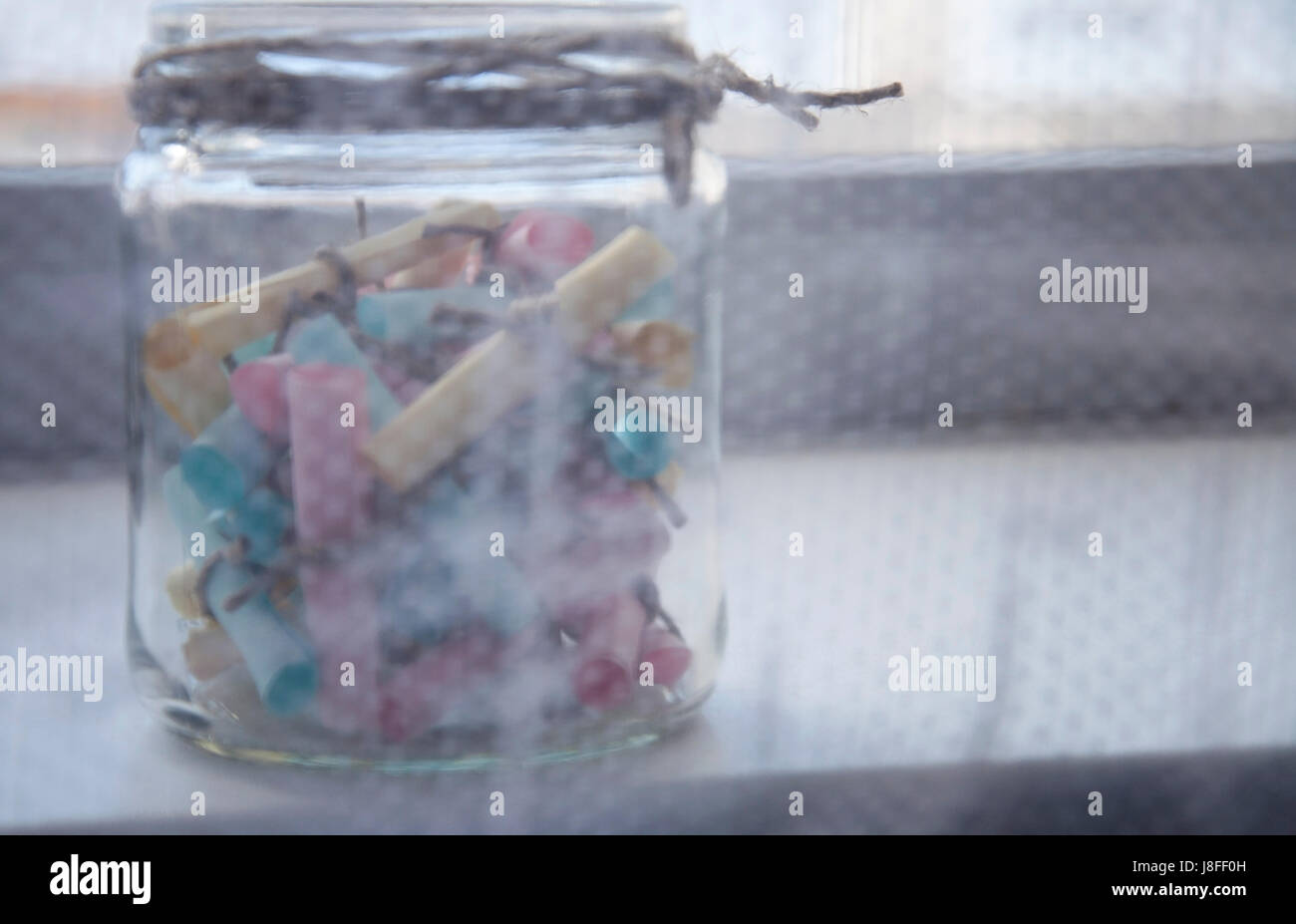 Glass jar with colored notes with blur and toning Stock Photo - Alamy