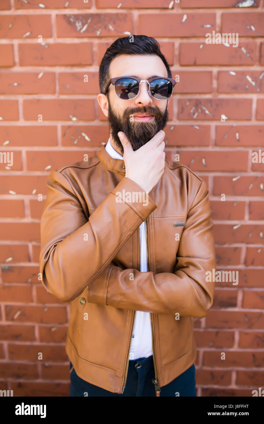Portrait of a brutal bearded man on brick wall background Stock Photo ...