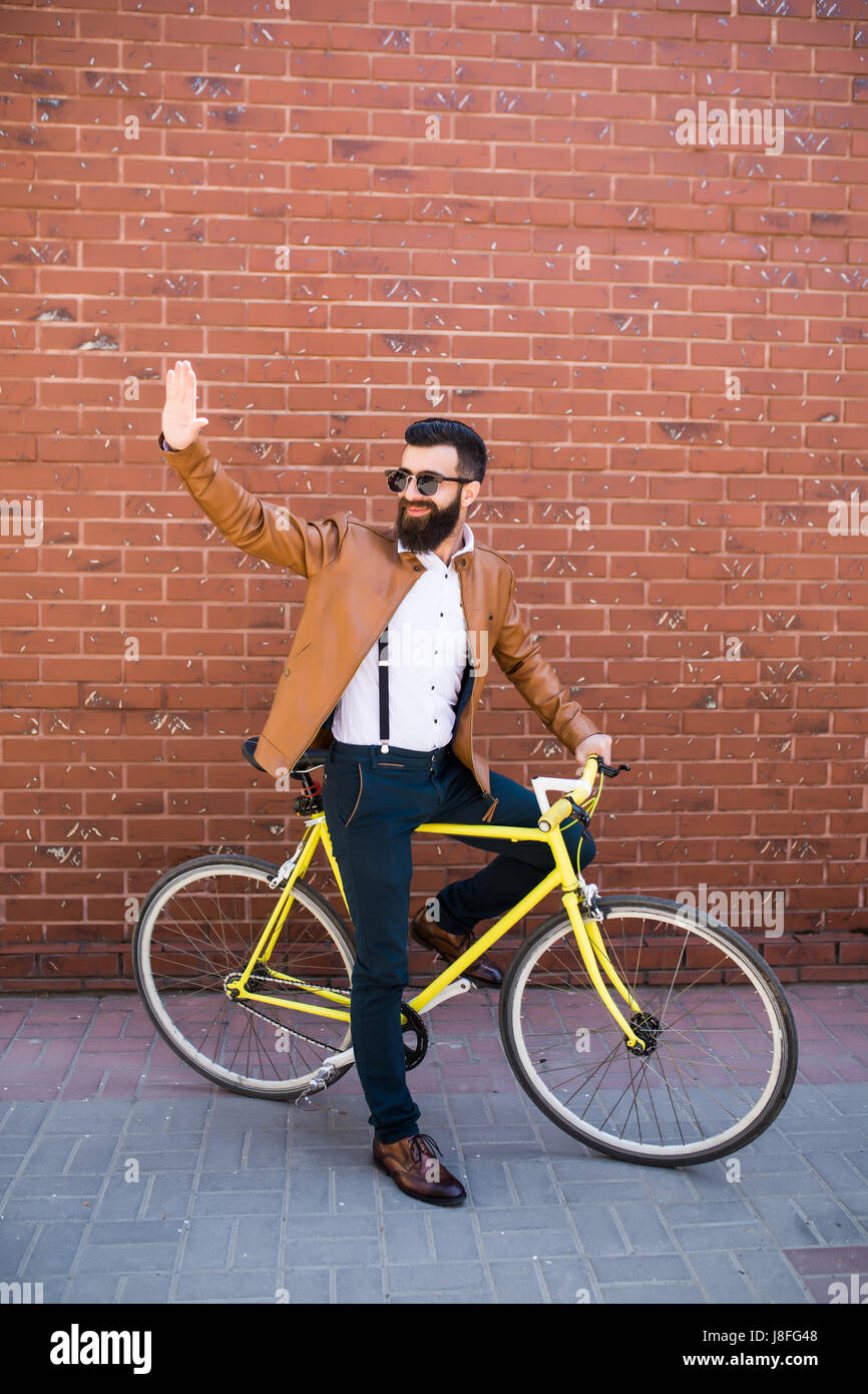 young hipster man with fixed gear bike waving hand on city street Stock ...