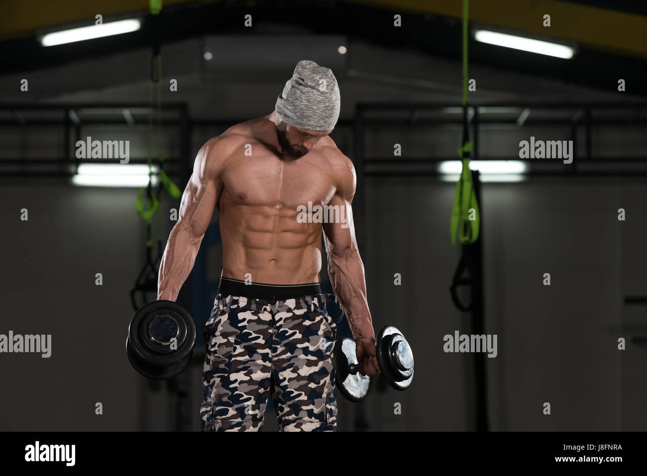 Man Working Out Biceps In A Dark Gym - Dumbbell Concentration Curls ...