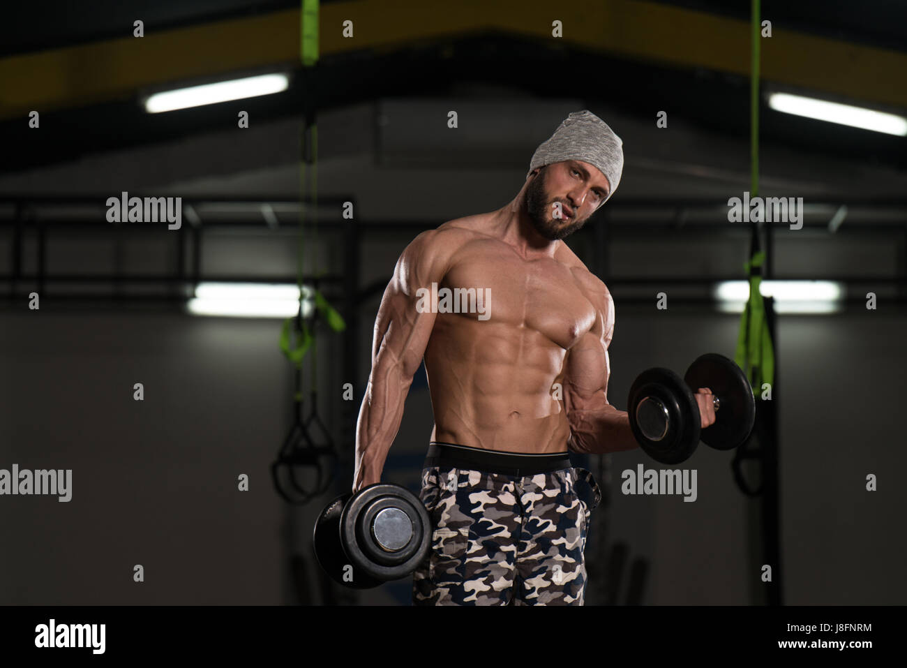 Man Working Out Biceps In A Dark Gym - Dumbbell Concentration Curls ...