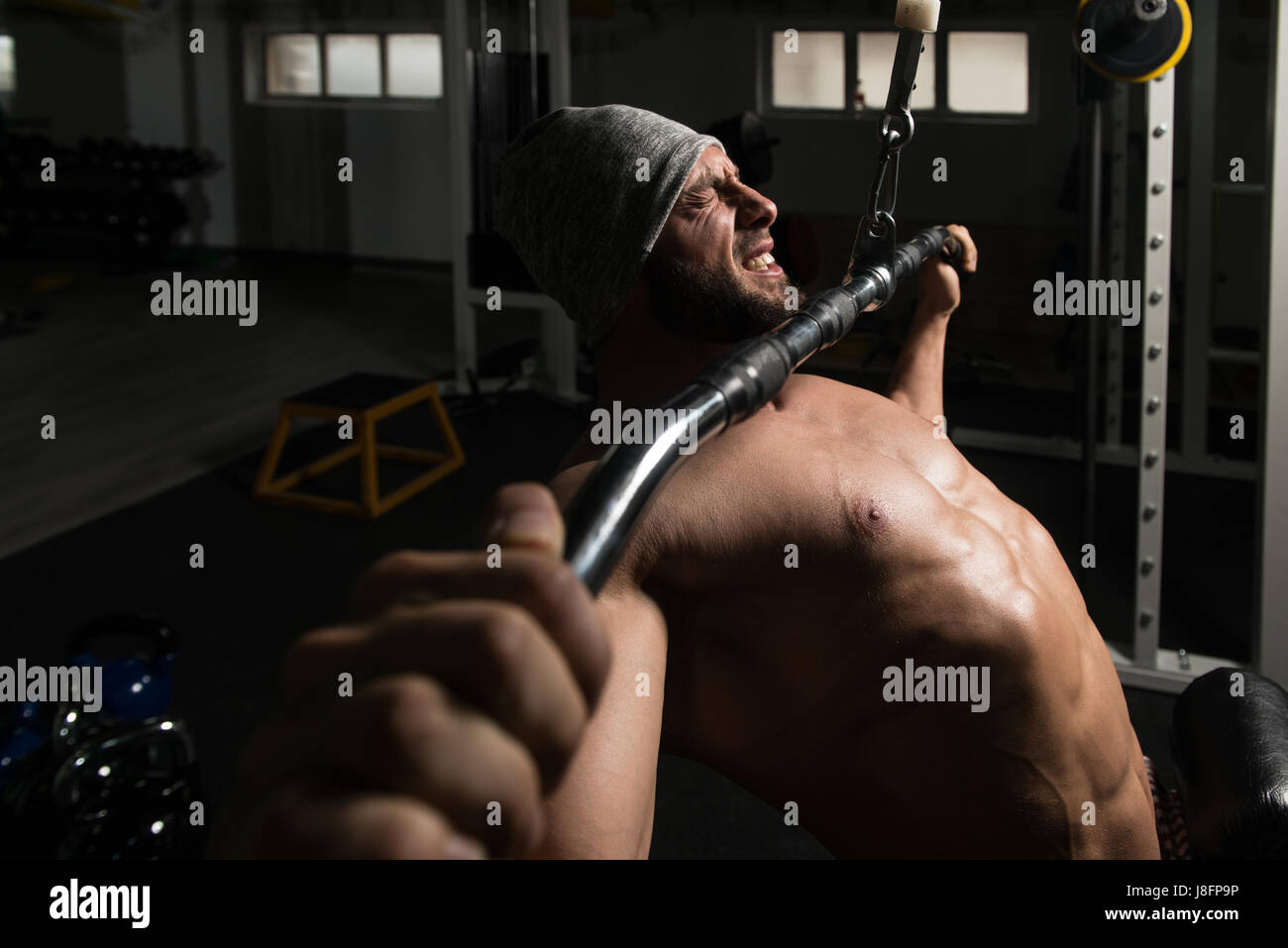 Handsome Bodybuilder Doing Heavy Weight Exercise For Back On Machine ...