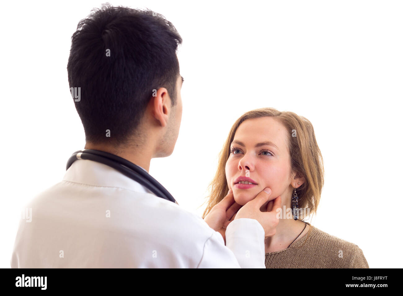 Young doctor with dark hair in white gown with stethoscope on his neck ...