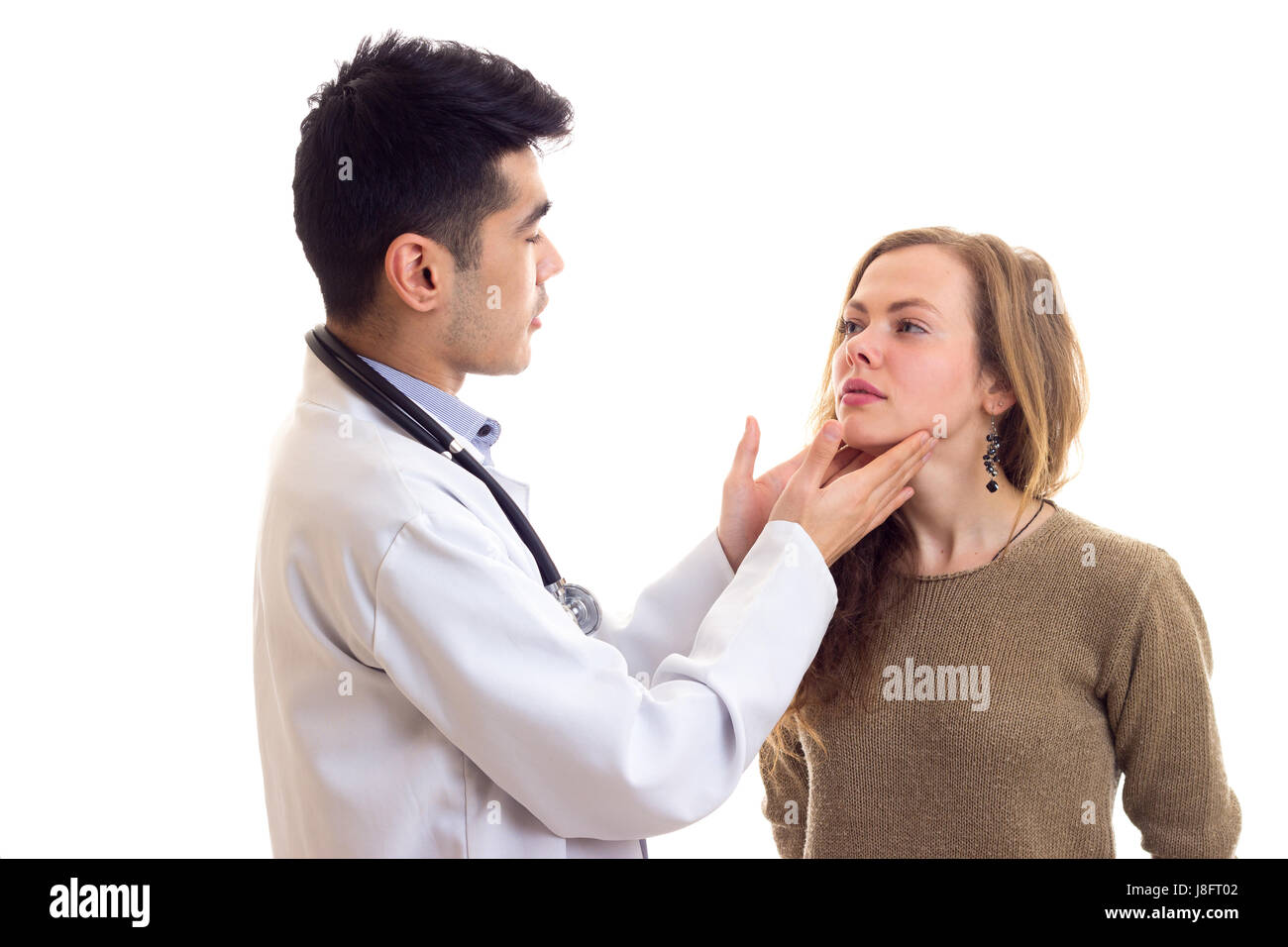 Young doctor with dark hair in white gown with stethoscope on his neck ...