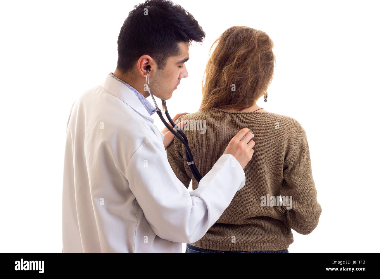 Young handsome doctor with dark hair in white gown with stethoscope ...
