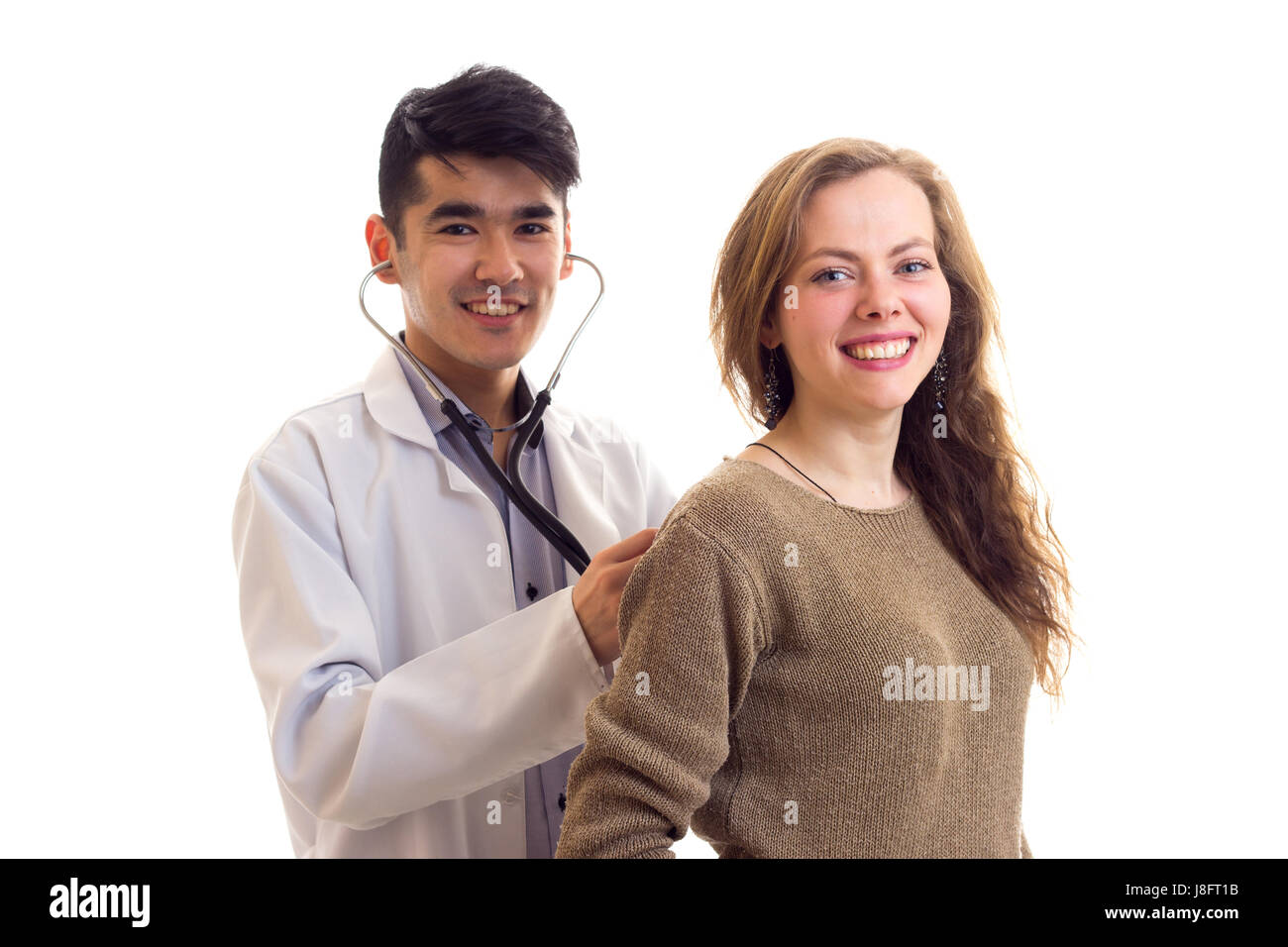 Young smiling doctor with dark hair in white gown with stethoscope ...