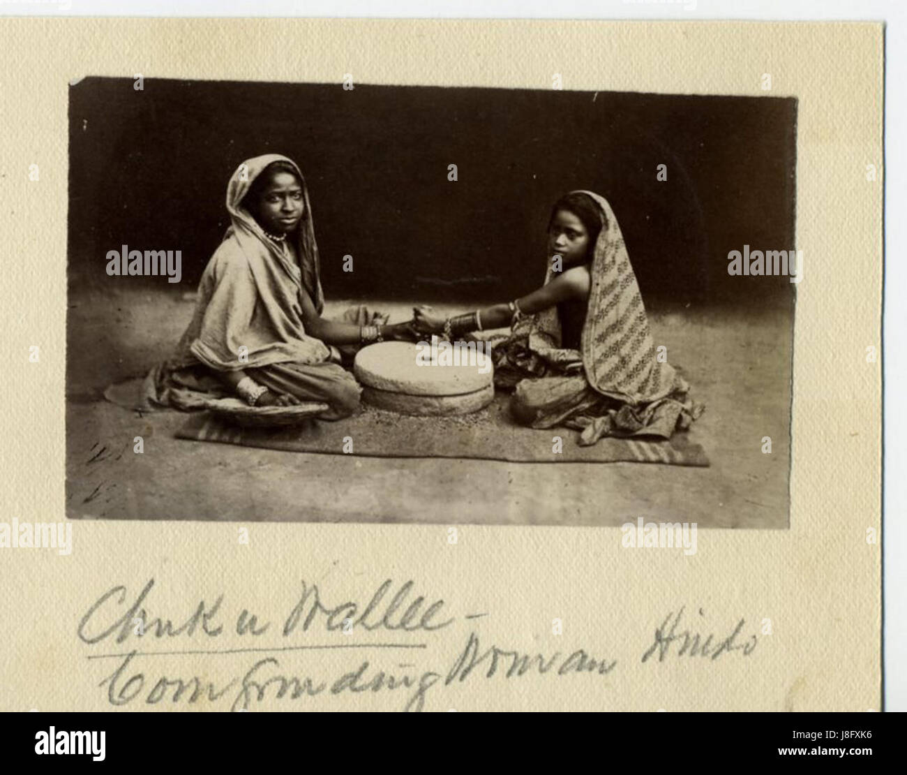 This historical image depicts Indian women grinding corn in the 1880s ...