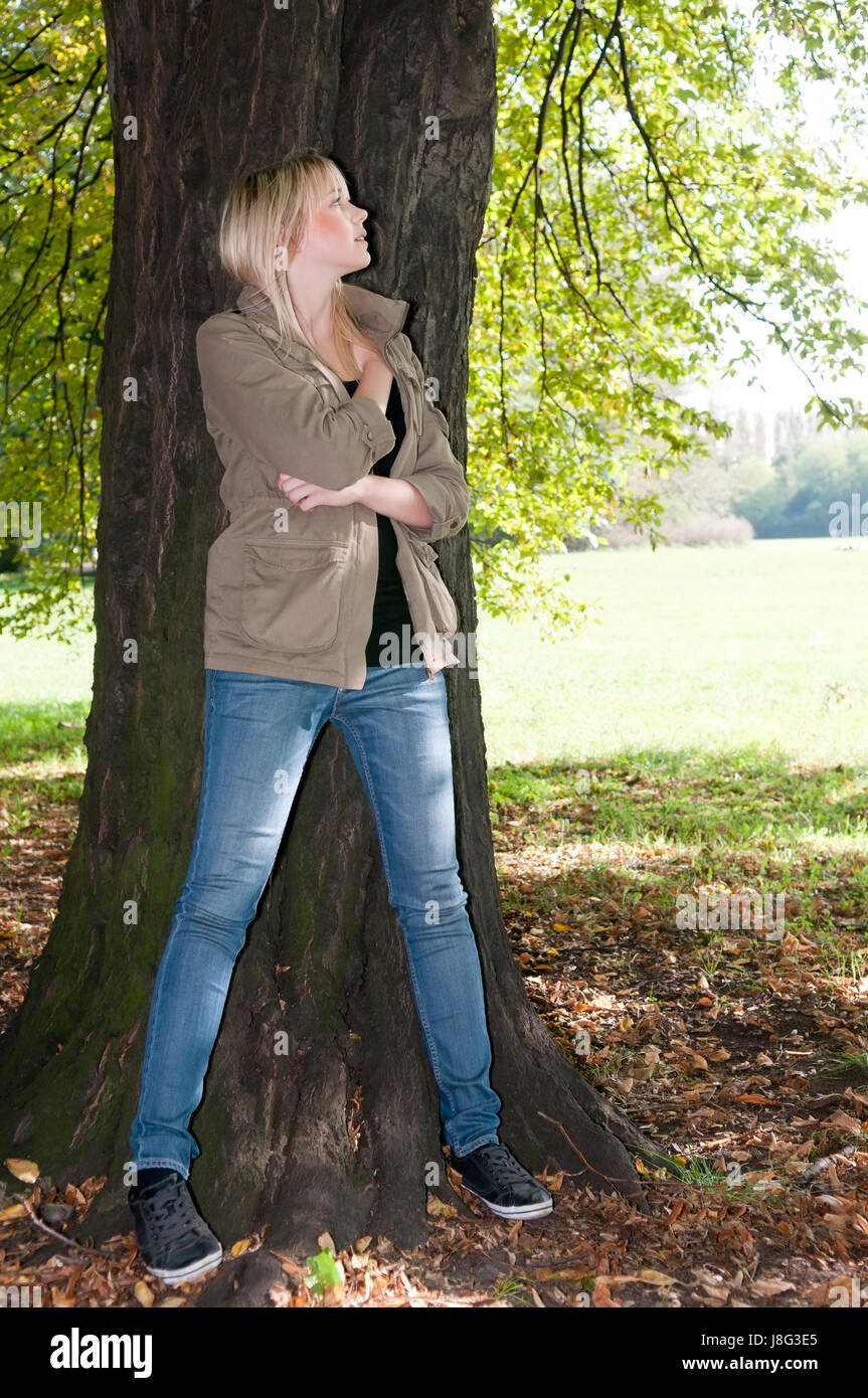 young woman stands on a tree Stock Photo - Alamy