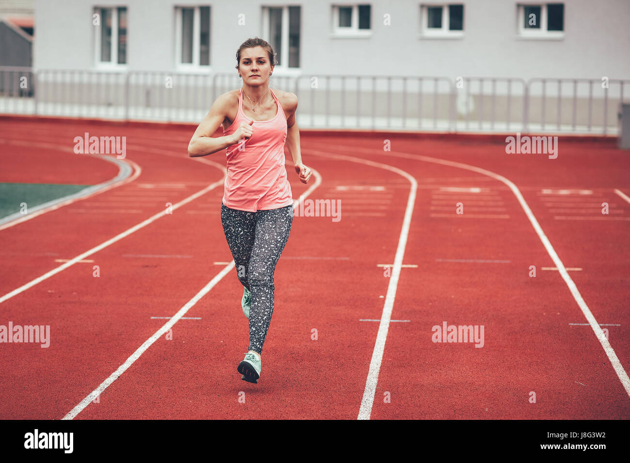 Muscular and beautiful girl doing exercises. Athletics girl, stadium ...