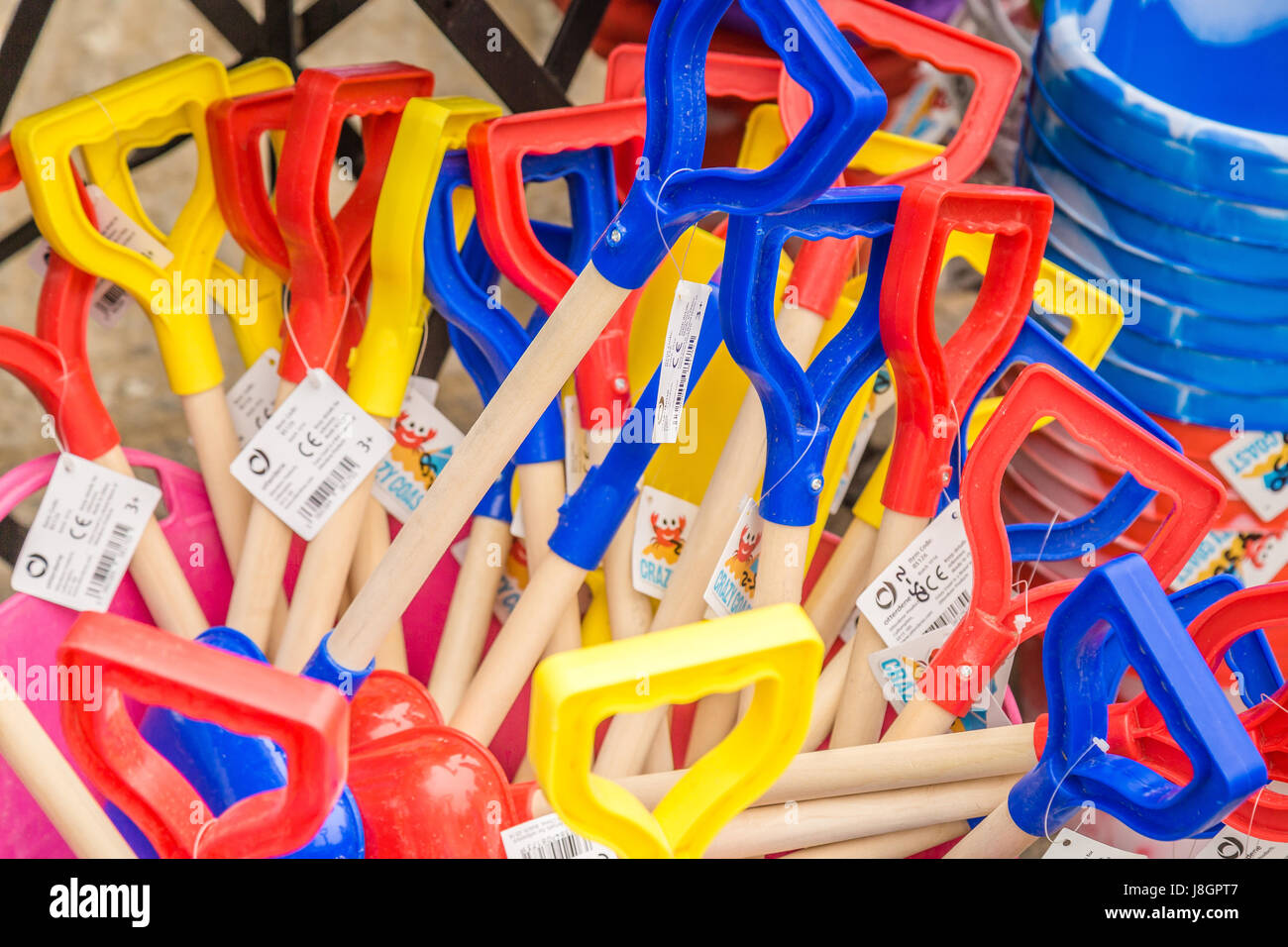 Brightly coloured plastic spades for kids Stock Photo - Alamy