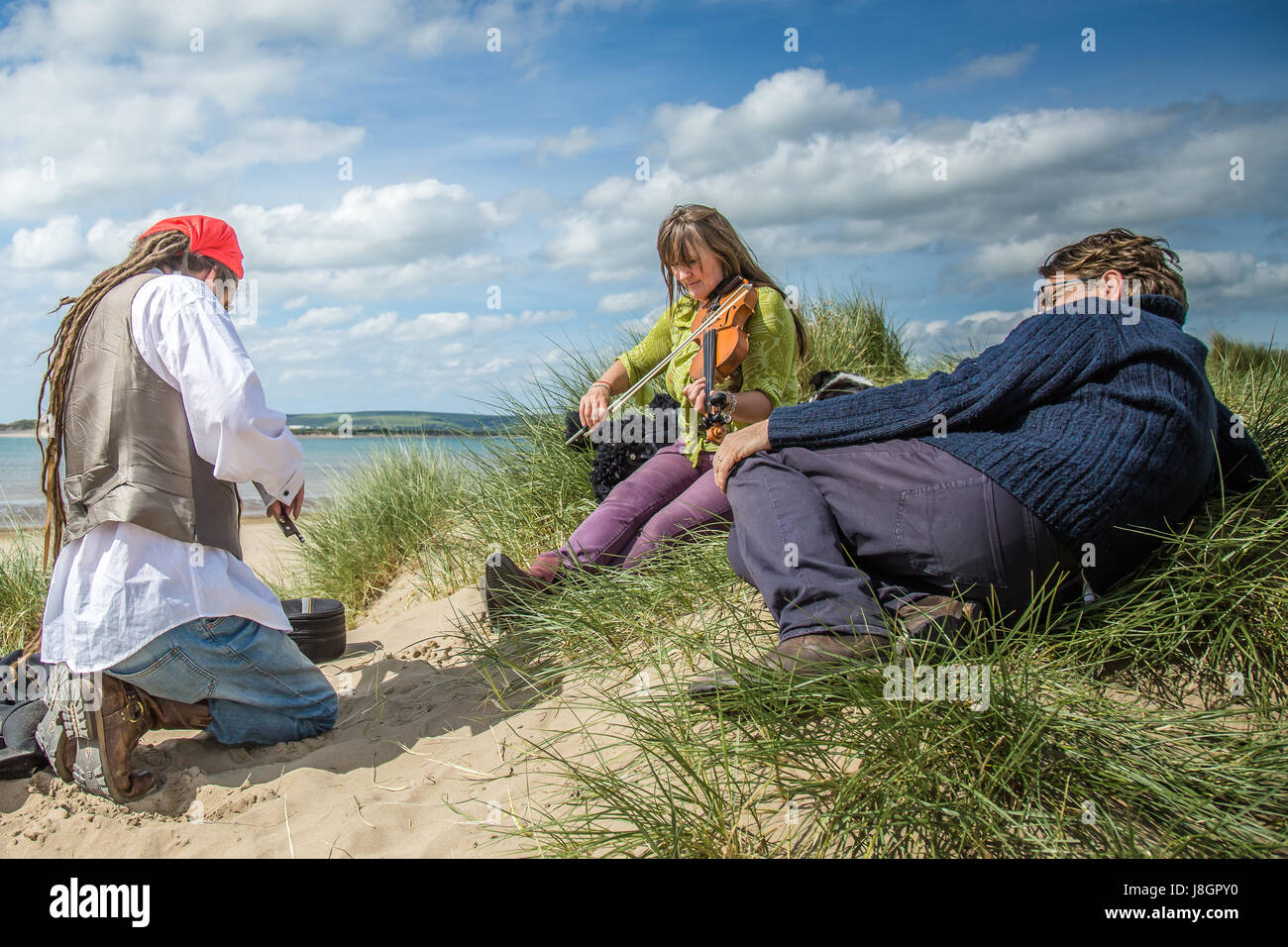 A folk group playing acoustic instruments on a sunny beach Stock Photo ...
