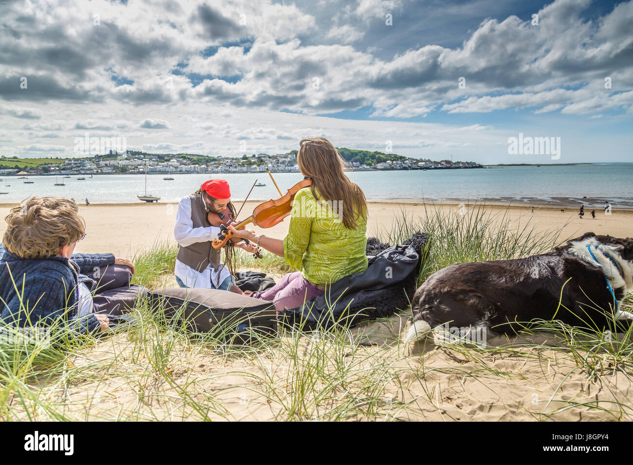 A folk group playing acoustic instruments on a sunny beach Stock Photo ...