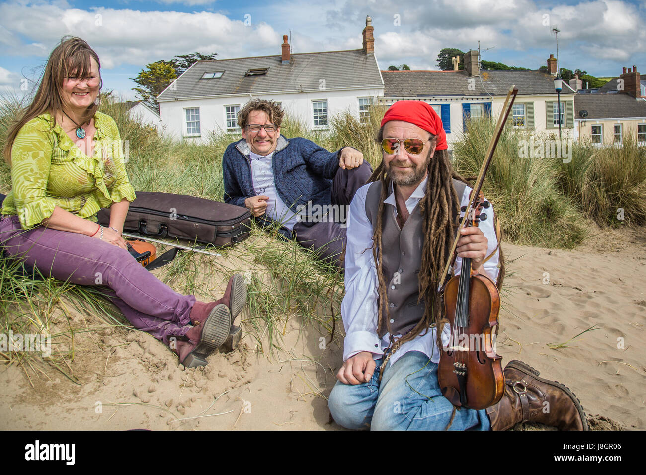 A folk group playing acoustic instruments on a sunny beach Stock Photo ...