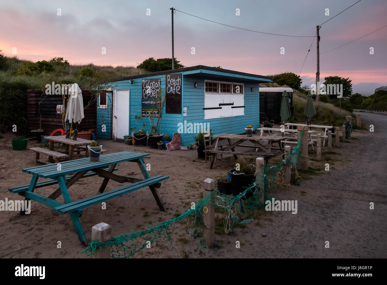 A wooden beach shack or cafe at sunset Stock Photo - Alamy