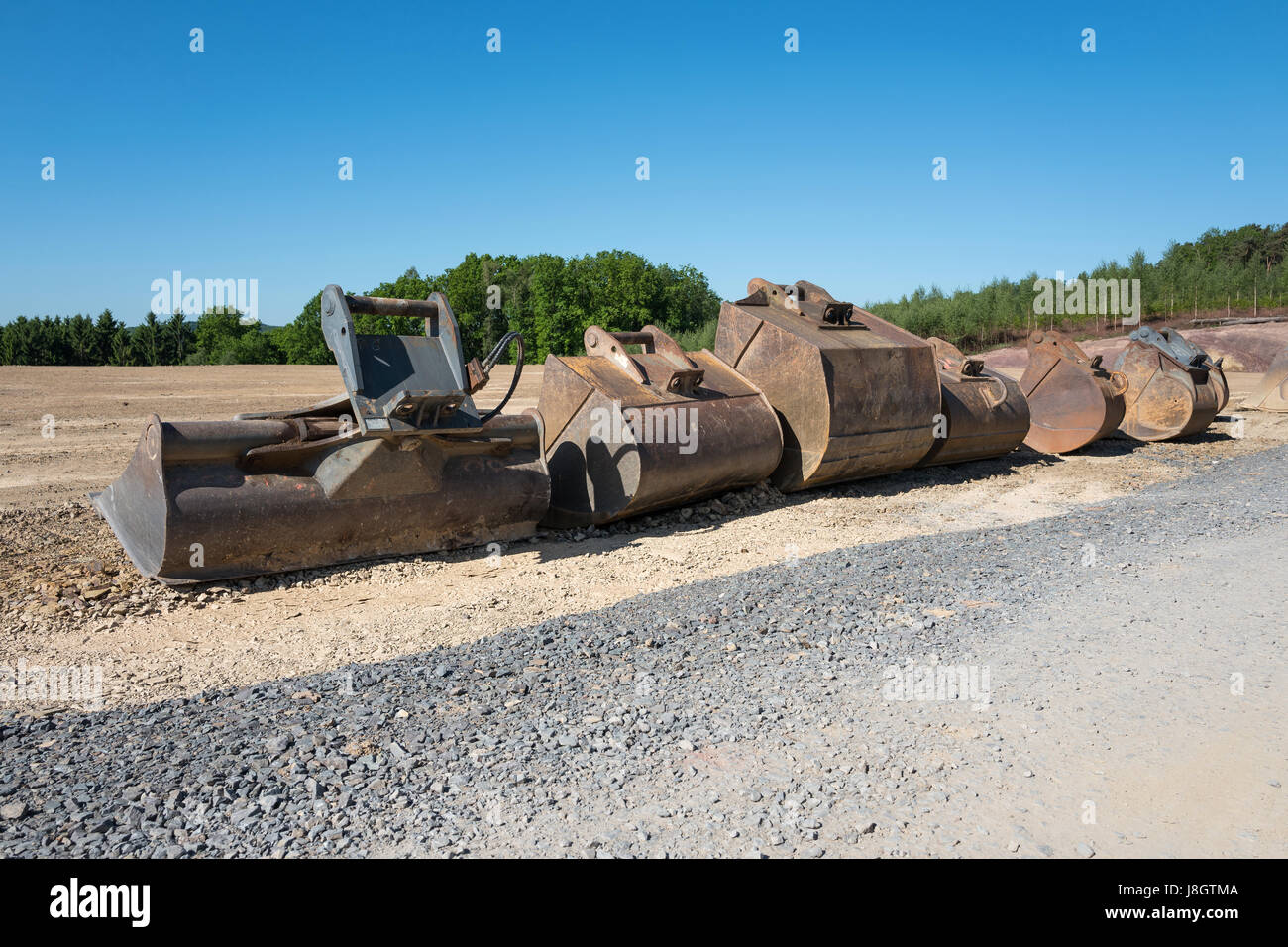 various excavation buckets at building site Stock Photo - Alamy