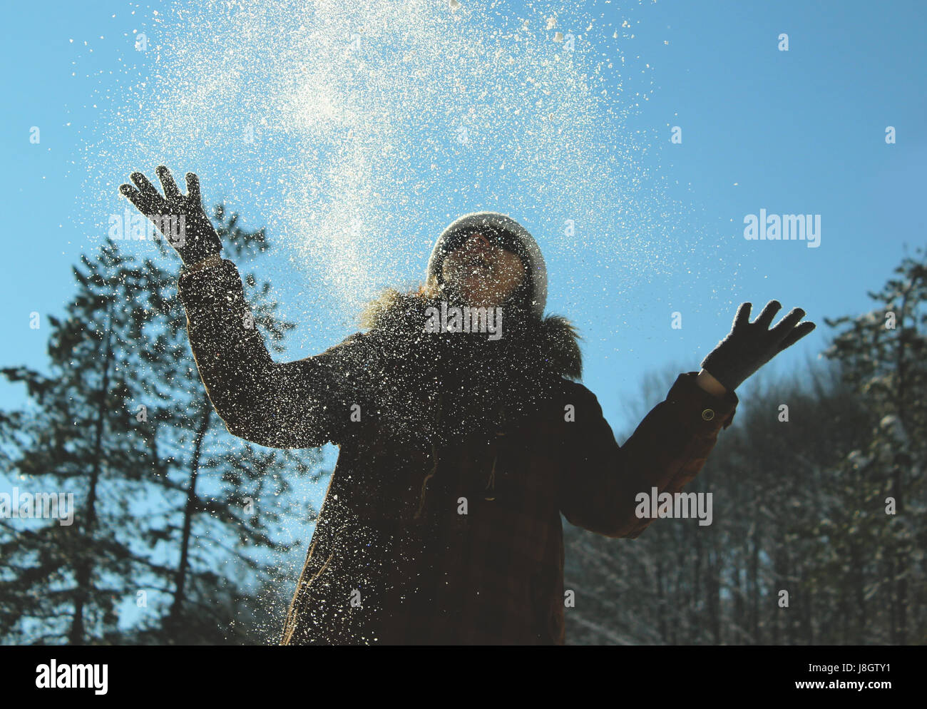 Woman throwing snow Stock Photo - Alamy