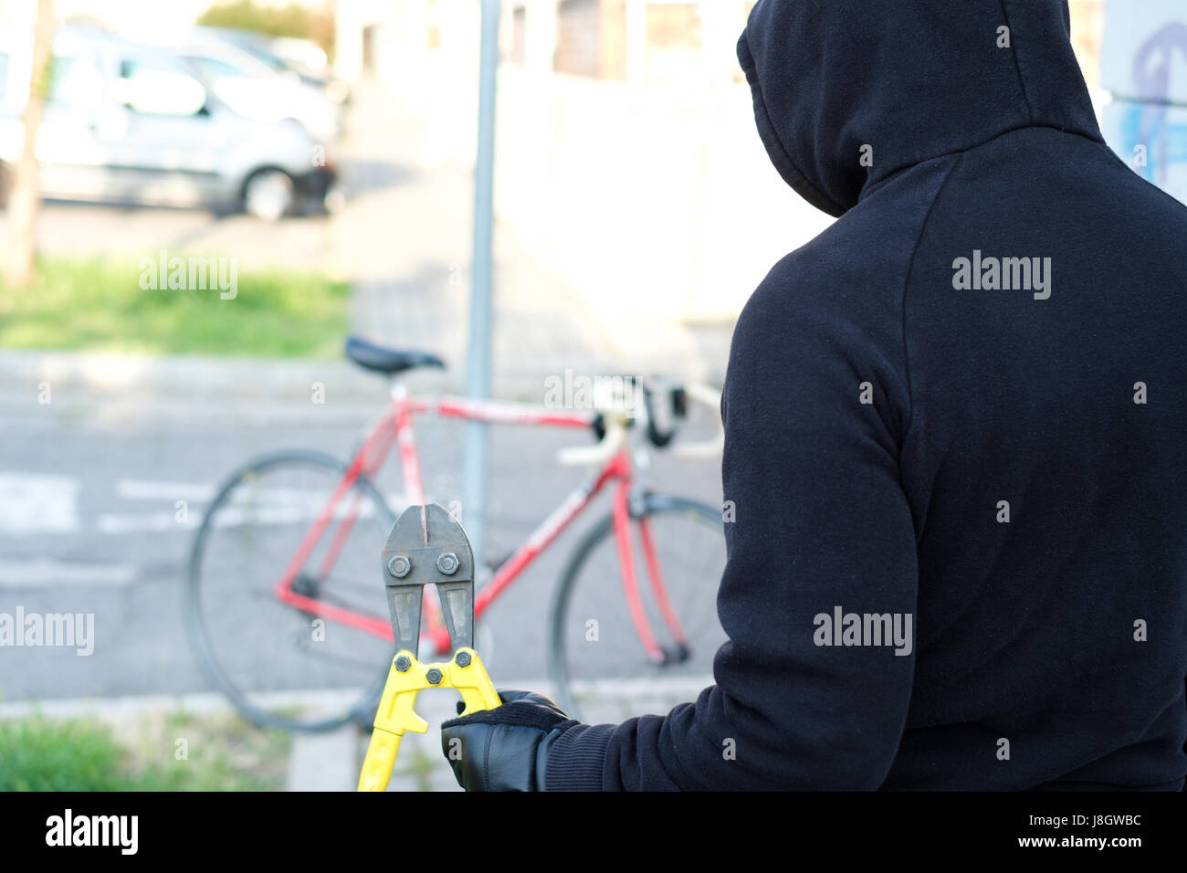 Thief stealing a parked bike in the city street Stock Photo - Alamy