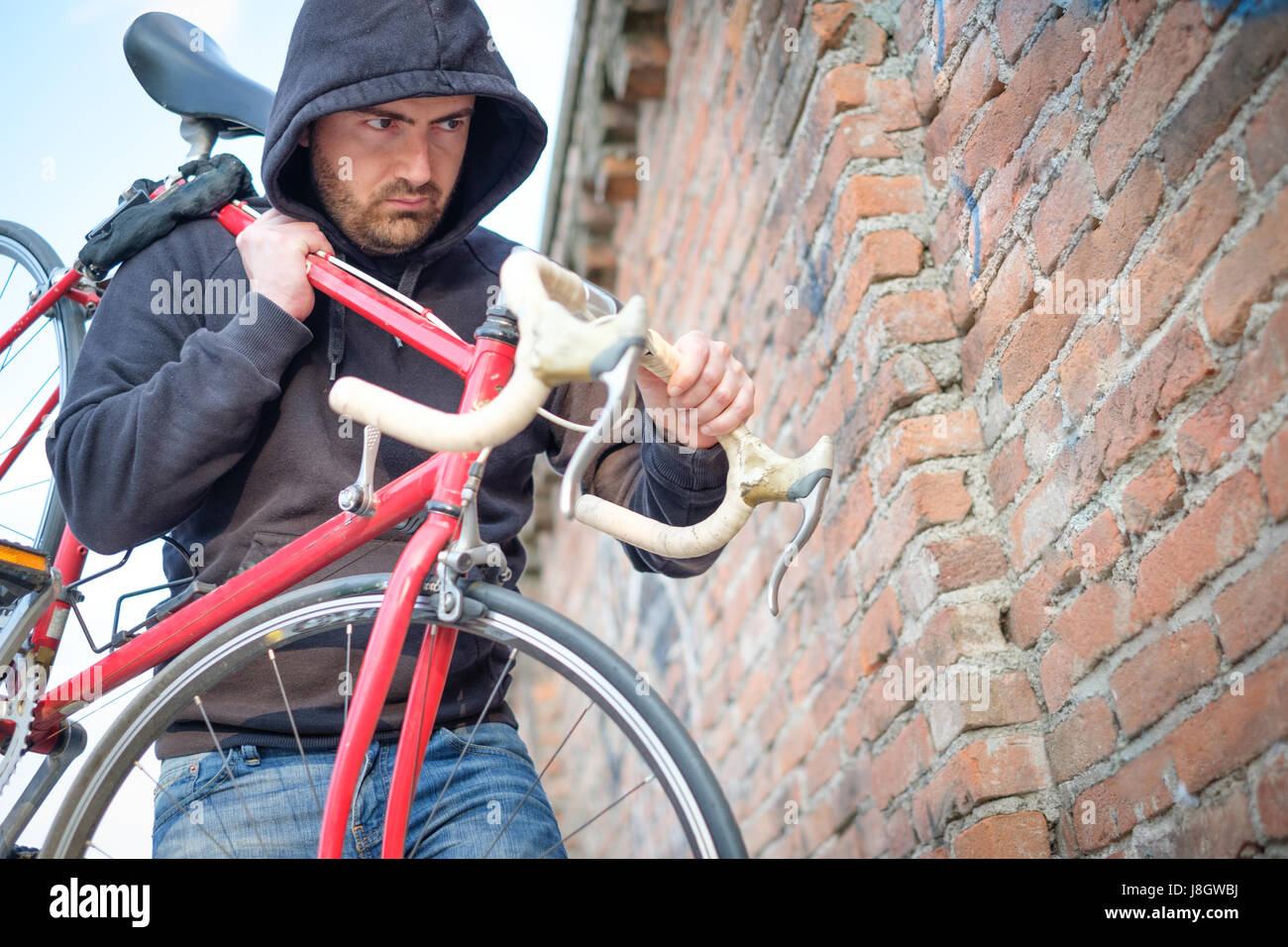 Thief stealing a parked bike in the city street Stock Photo - Alamy