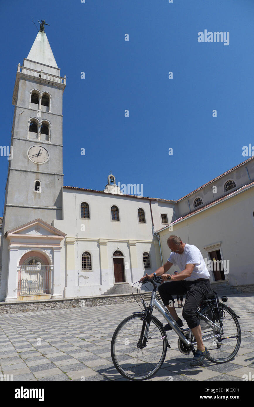 A man cycling a long the church in Croatia Stock Photo - Alamy