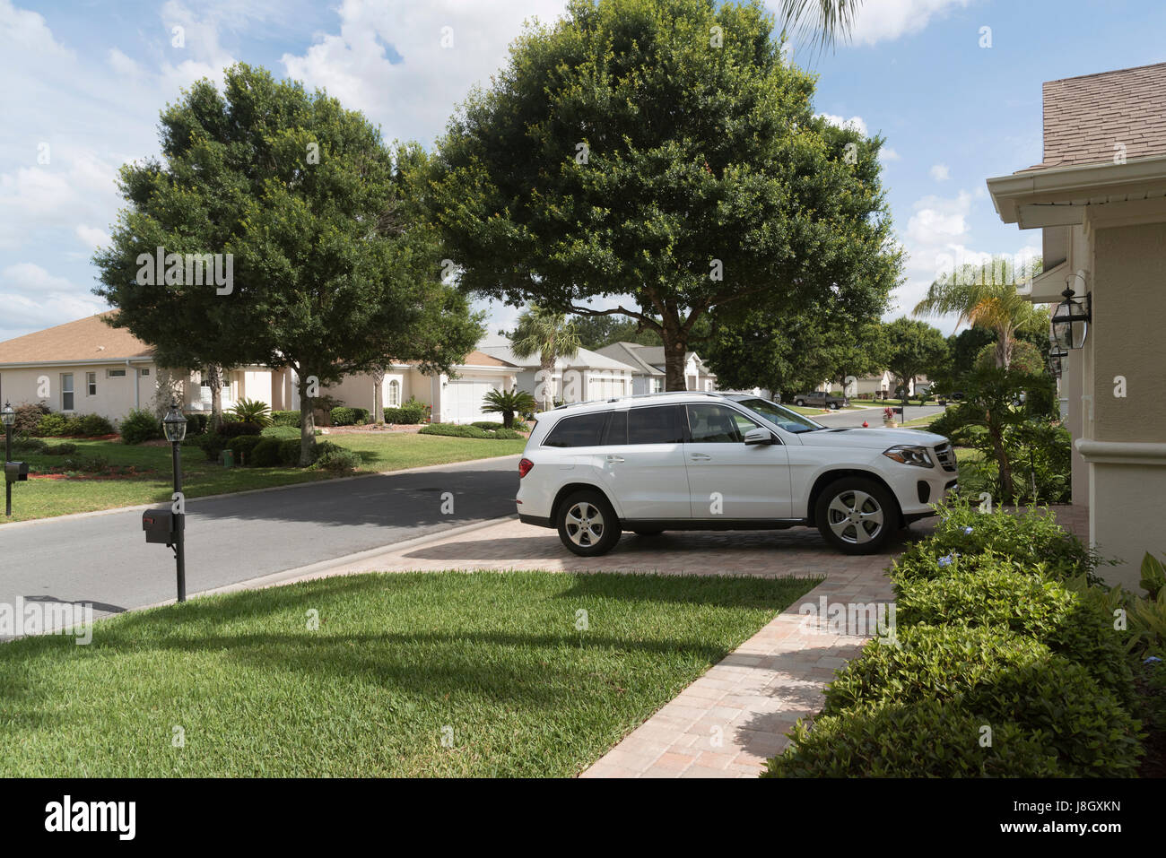 Luxury car parked on the driveway of a house in a Florida residential ...