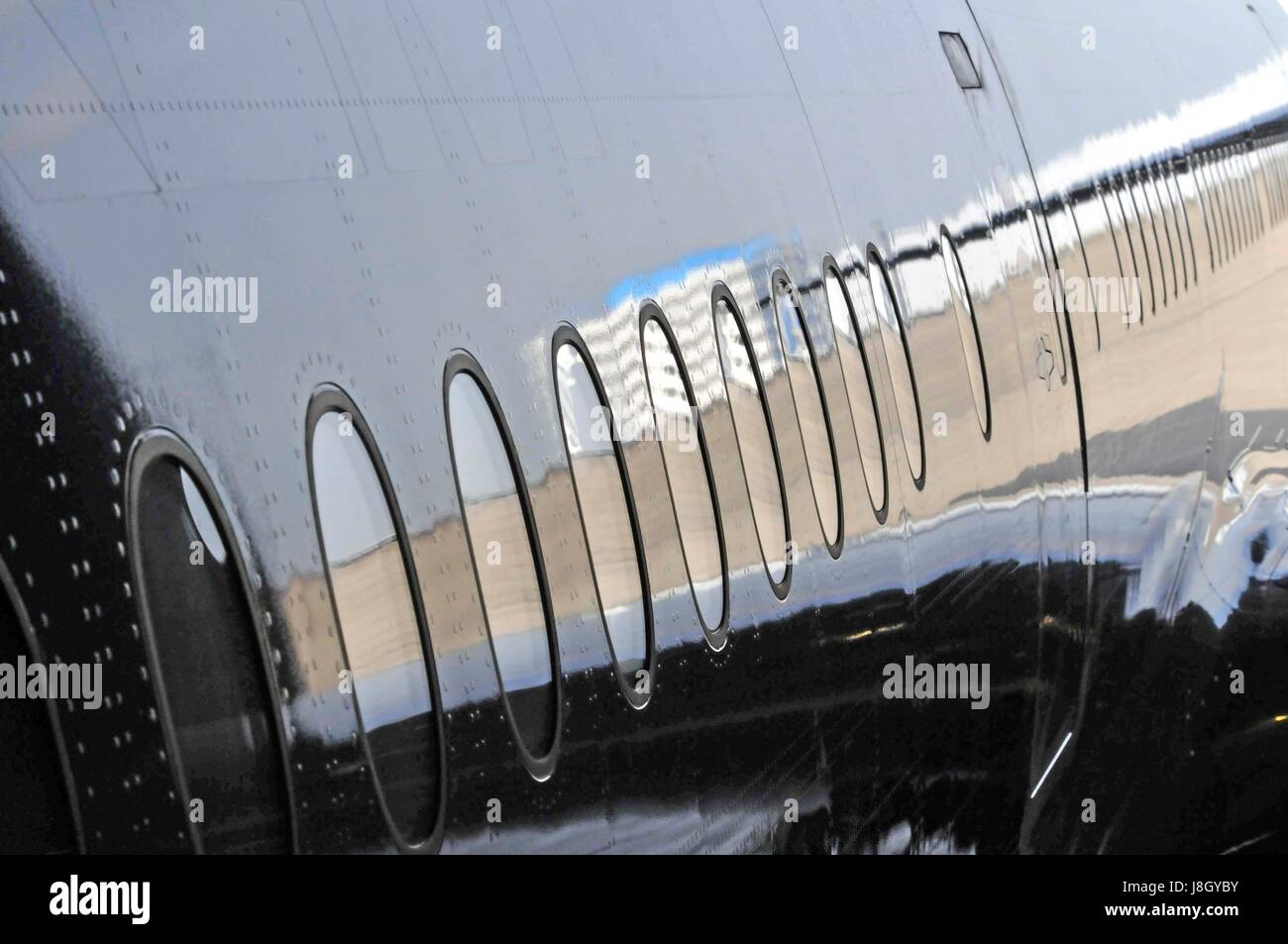 A row of airplane windows on the side of an airplane. You can see the ...
