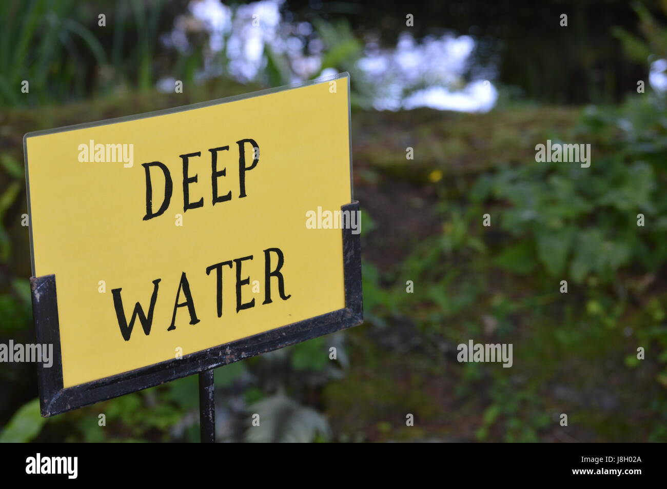 Deep water warning sign beside waters edge Stock Photo - Alamy