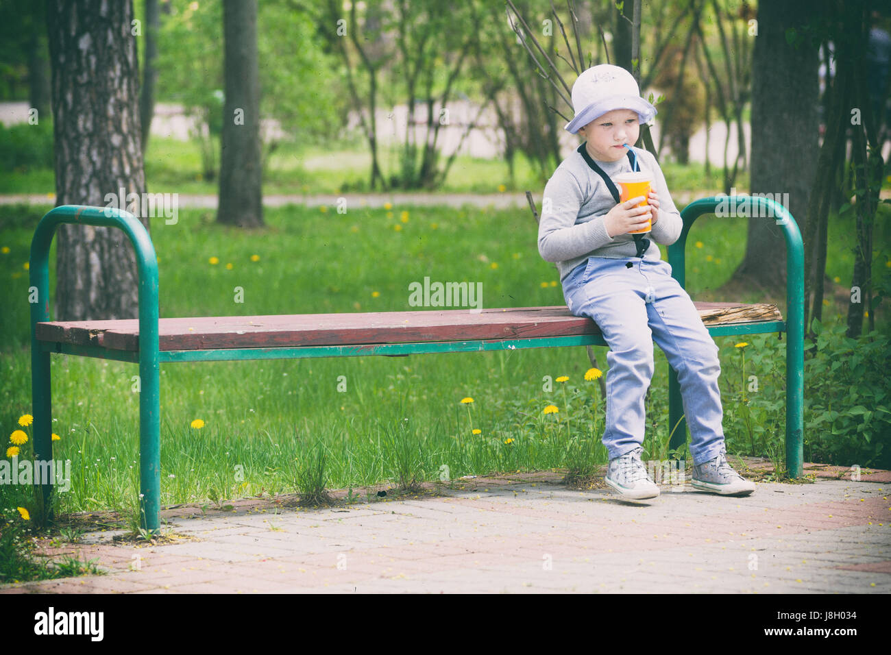 Trendy boy in pajamas sitting on the bench with a cocktail Stock Photo ...