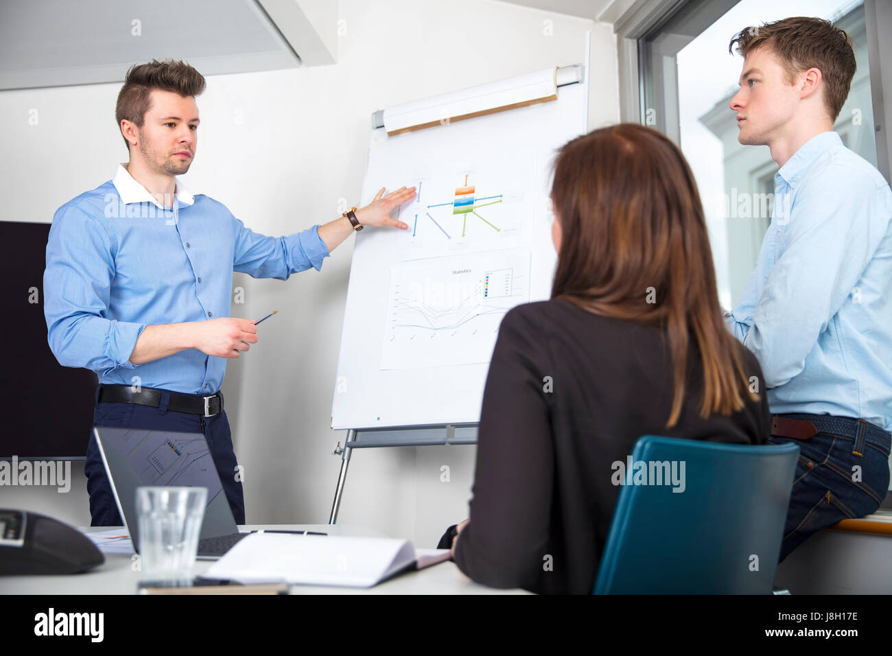 Businessman Explaining Chart To Male And Female Colleagues Stock Photo ...