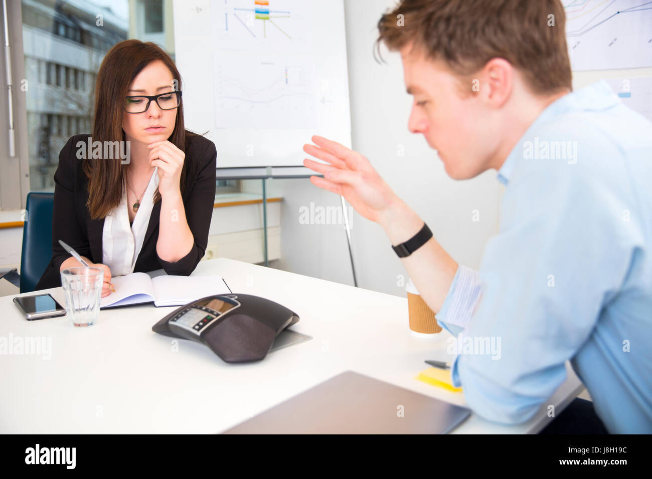 Business People Using Conference Phone At Meeting Desk Stock Photo - Alamy