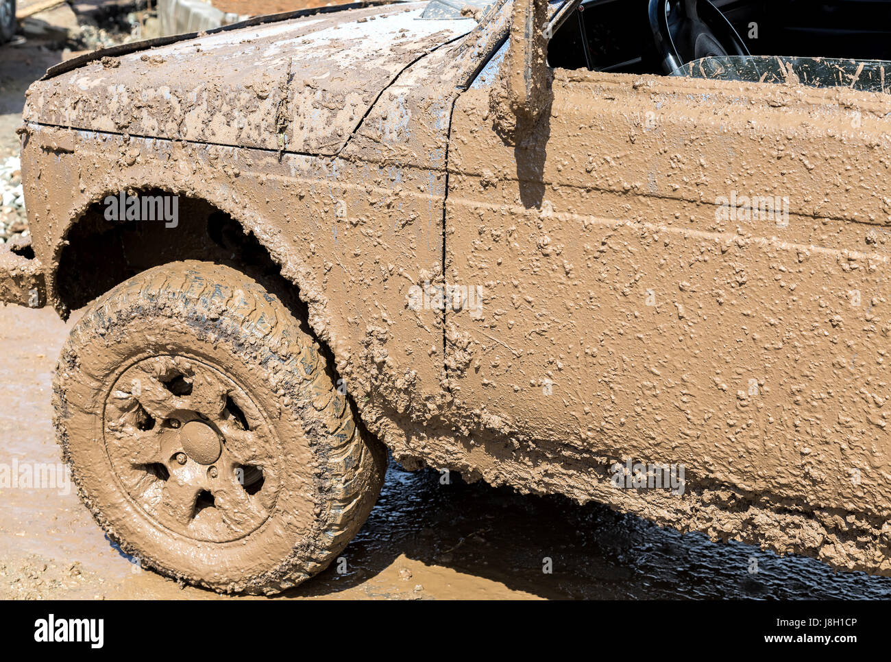 Off-road vehicle after driving in the rain on extremely dirty rural ...