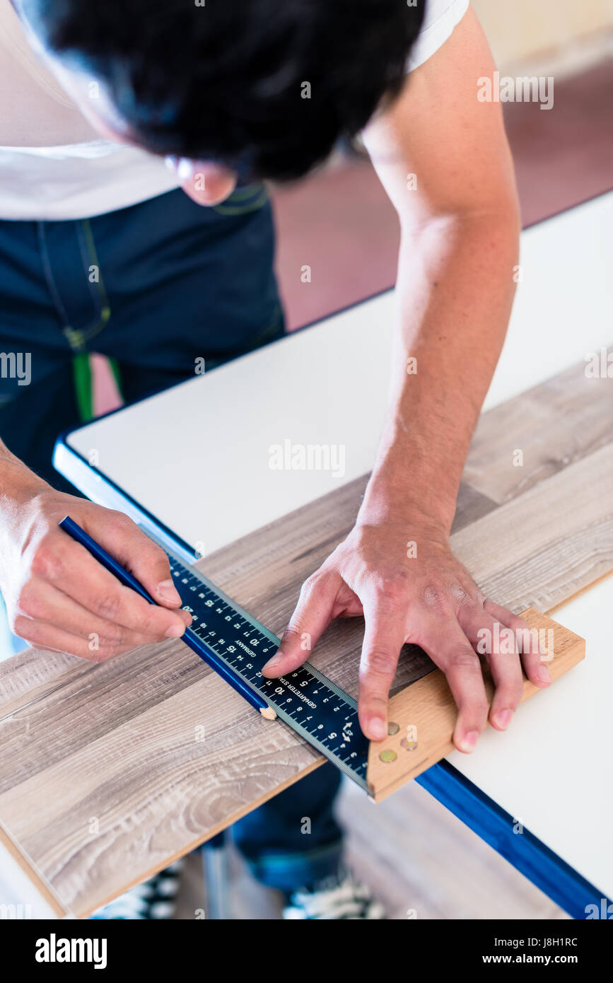 Carpenter marking cut on parquet piece Stock Photo - Alamy