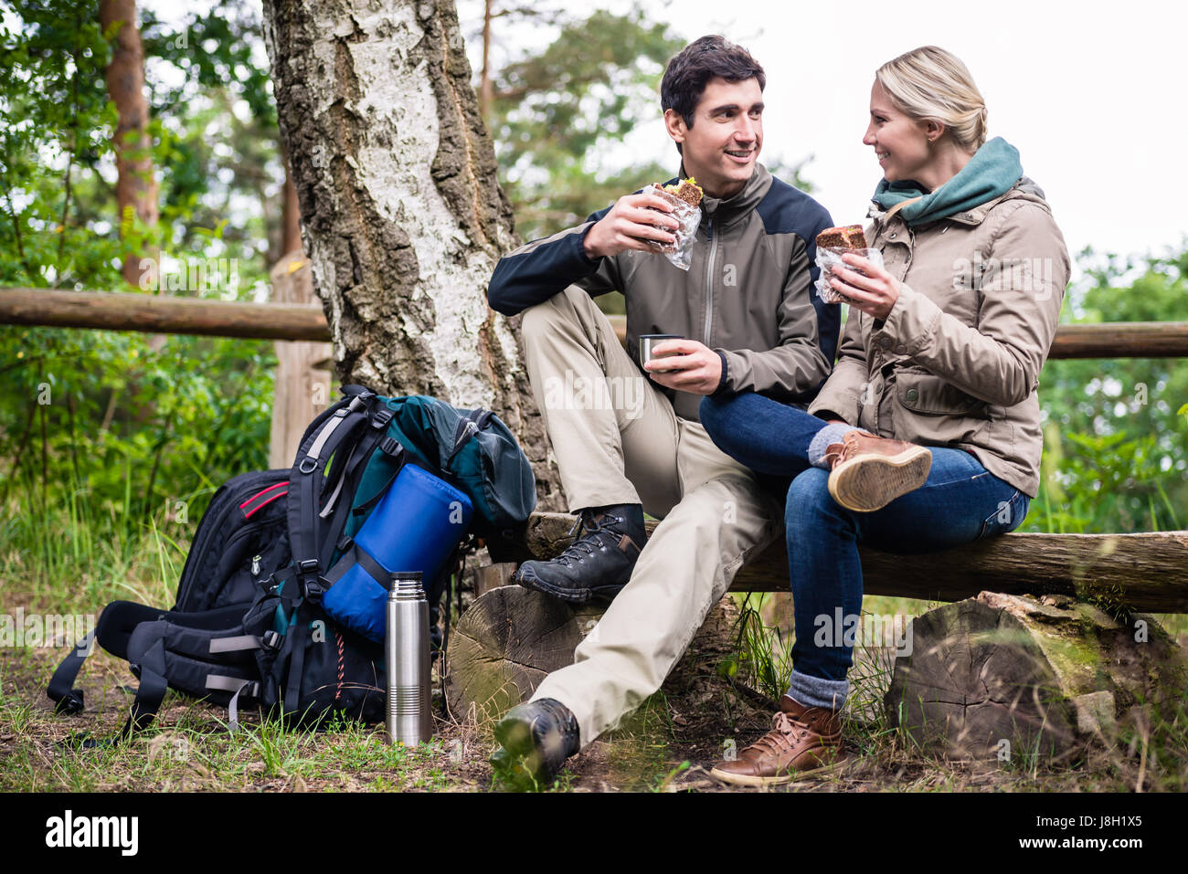 Couple on hike taking rest under tree Stock Photo - Alamy