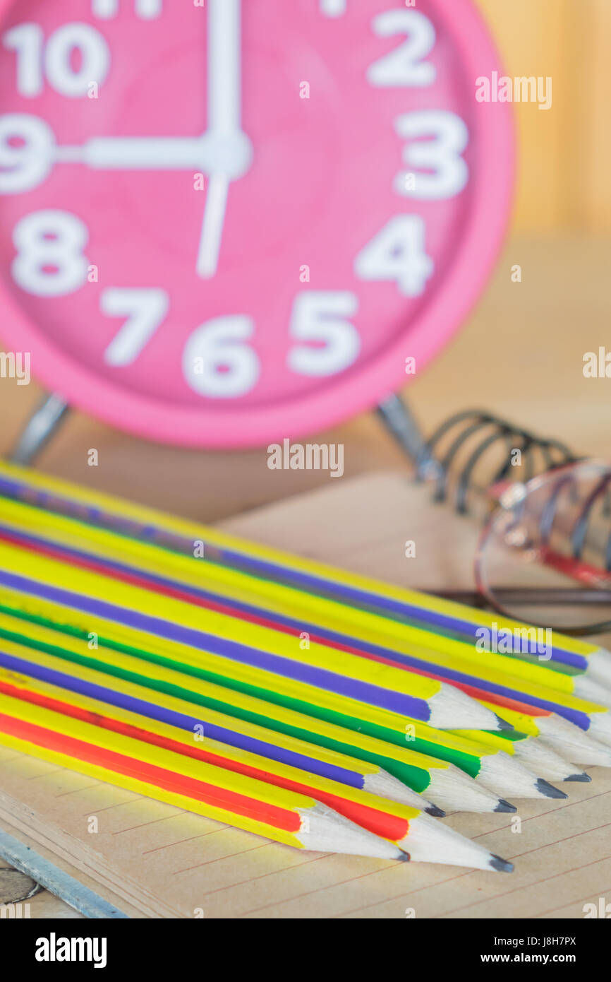 Pencil, Alarm clock, on a book background Stock Photo - Alamy