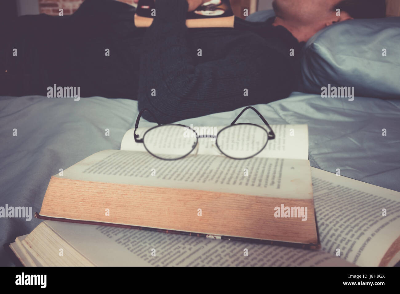 Man sleeping, reading and sleeping Stock Photo - Alamy