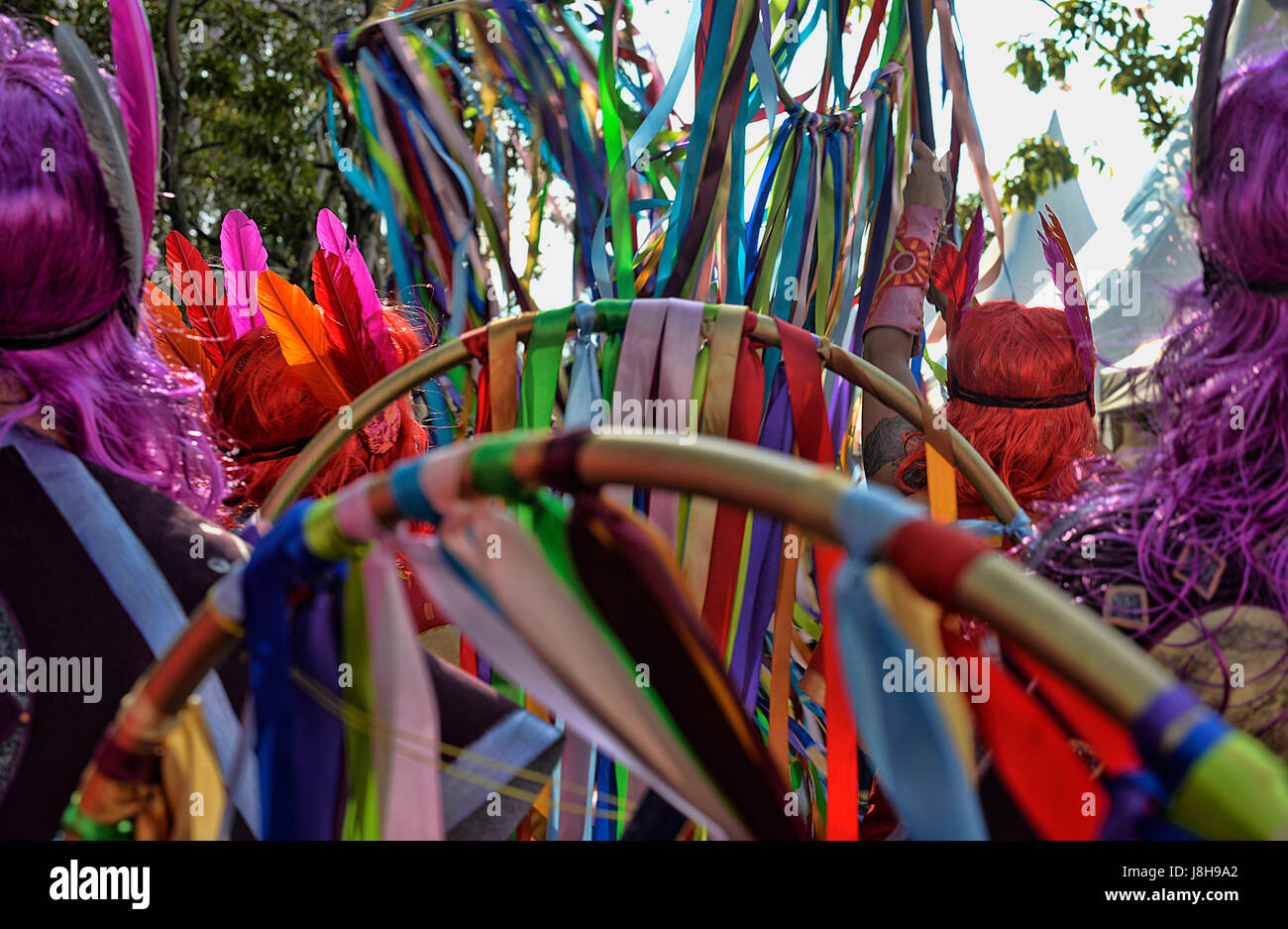 Marchers carry hula hoops covered with colored ribbons during a ...